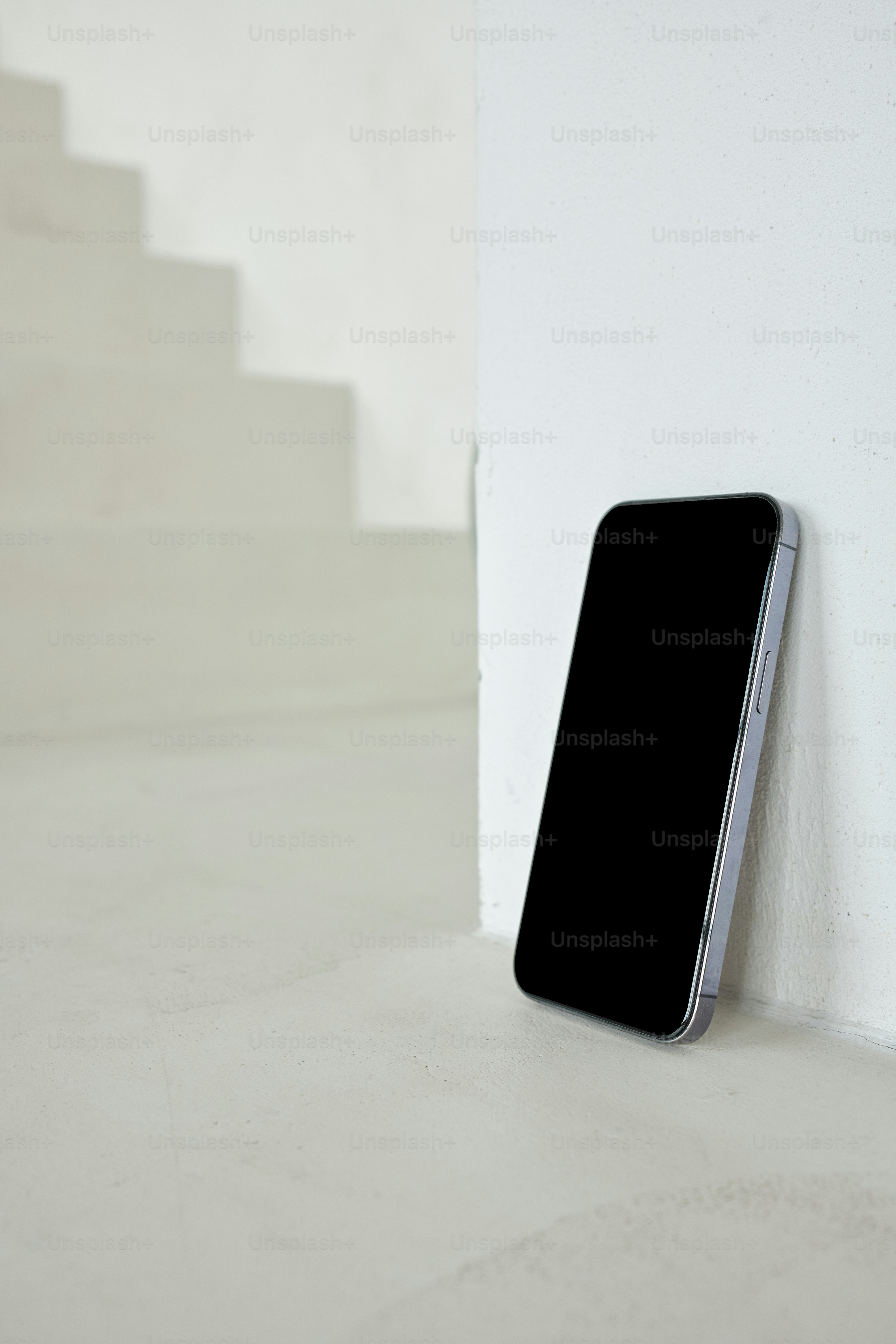 A cell phone sitting on the ground next to a stair case photo ...