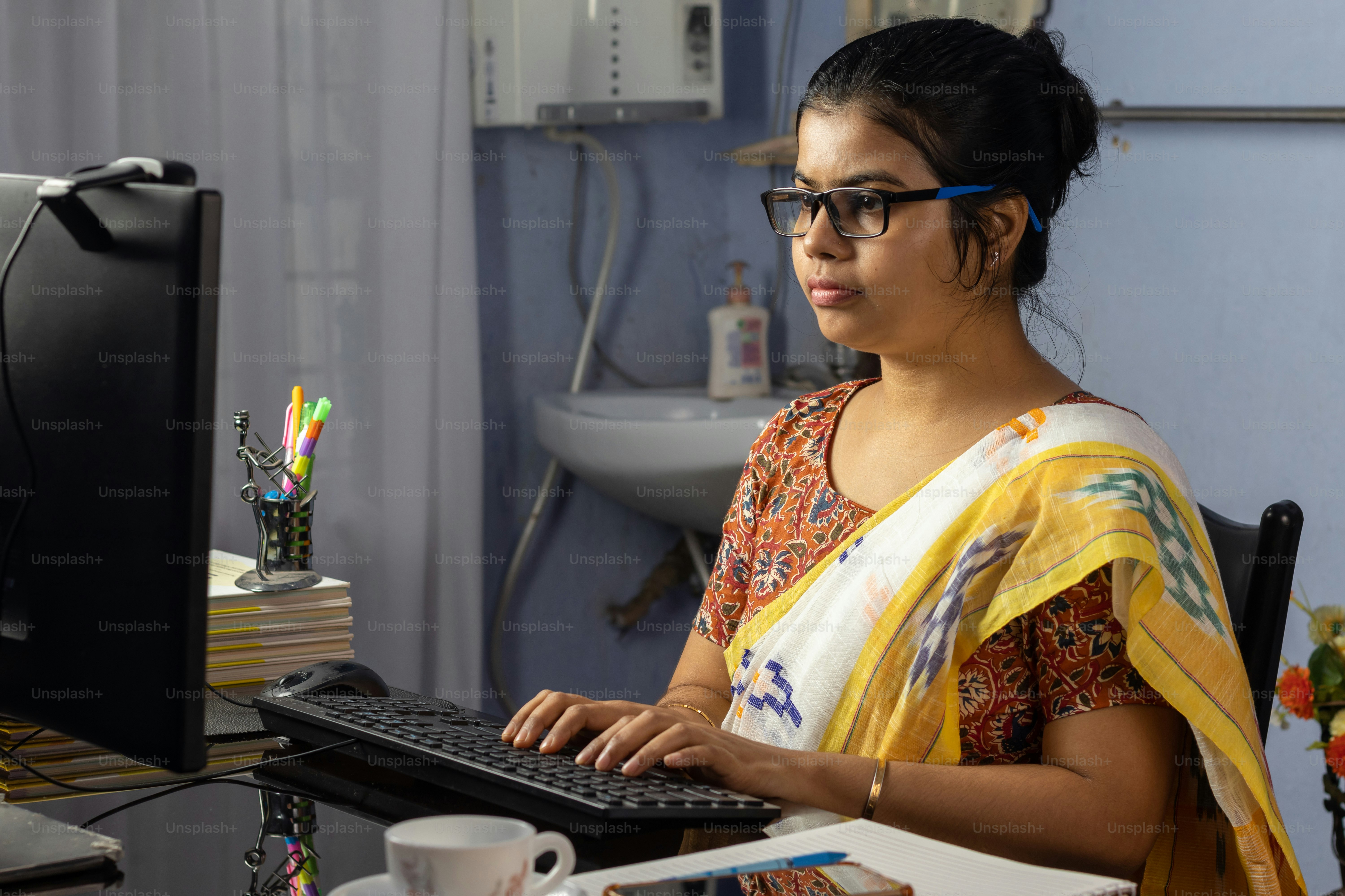 Indian woman in saree working on computer at home, work from home ...