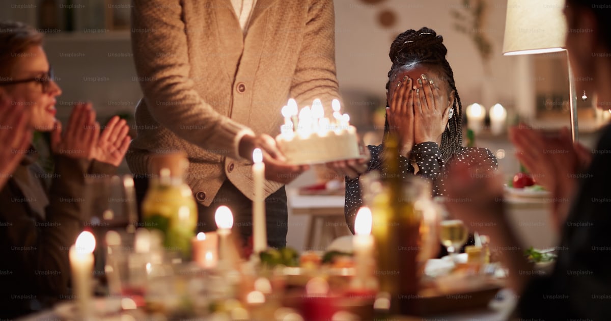 아프리카 여자는 남자 친구가 파티 중에 생일 케이크를 들고 있는 동안 손으로 눈을 감고 있다 사진 Unsplash의 성인 이미지
