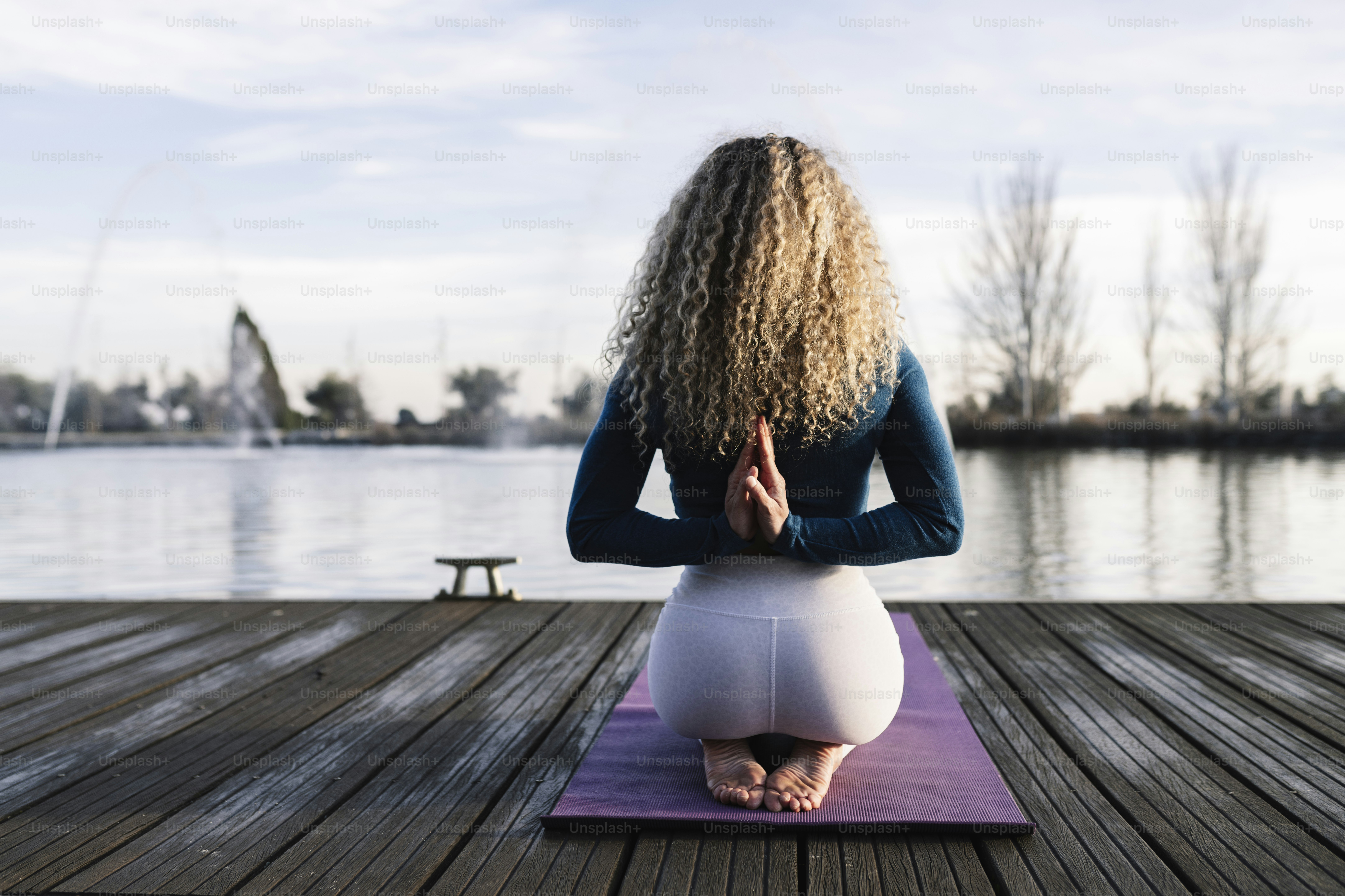 Foto Mujer rubia bonita con cabello rizado, haciendo yoga relajada ...