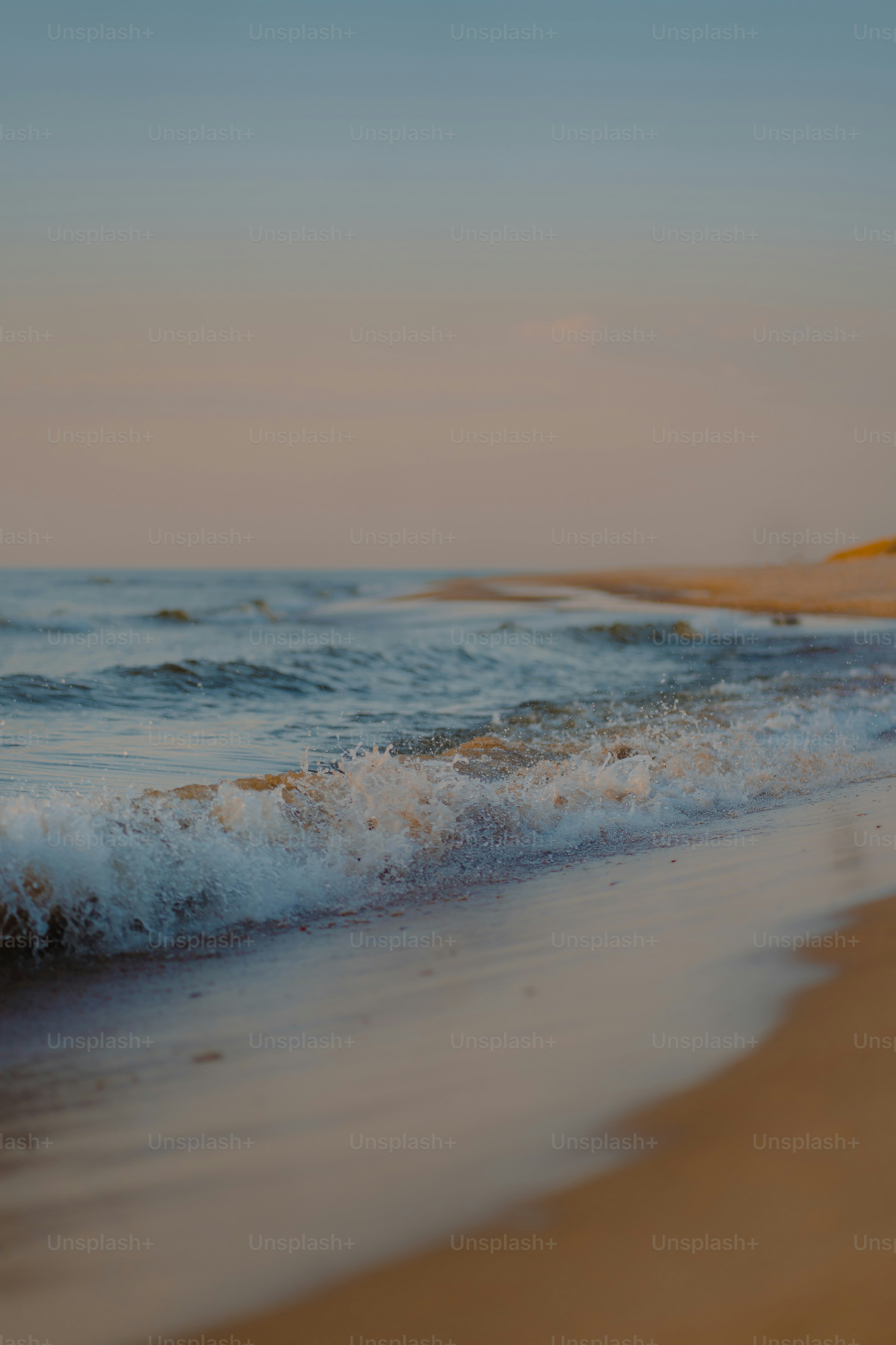 A beach with waves coming in to shore photo – Wallpaper Image on Unsplash