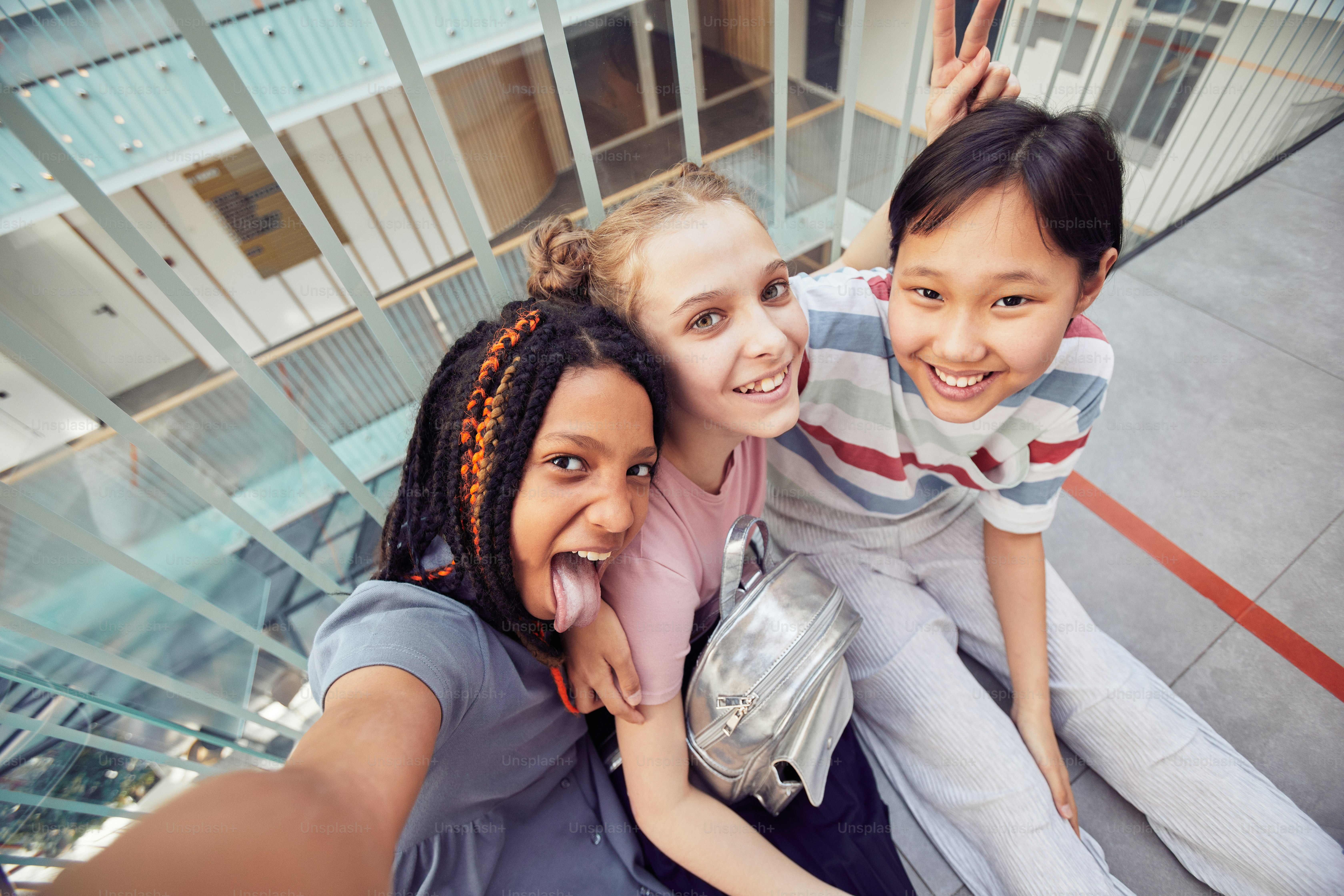POV high angle view at diverse group of schoolgirls taking selfie ...