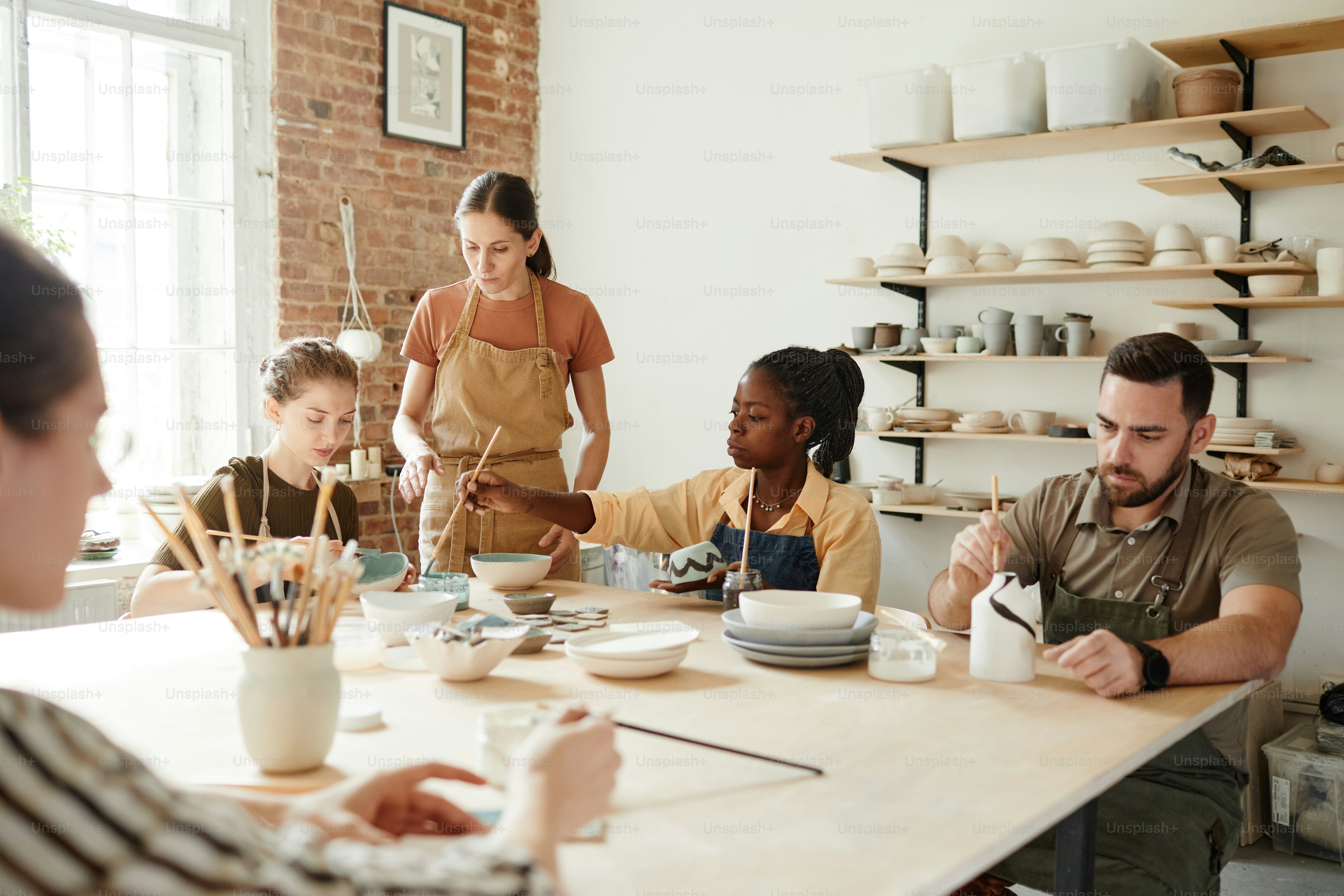 Warm toned portrait of diverse group of people decorating ceramics in ...