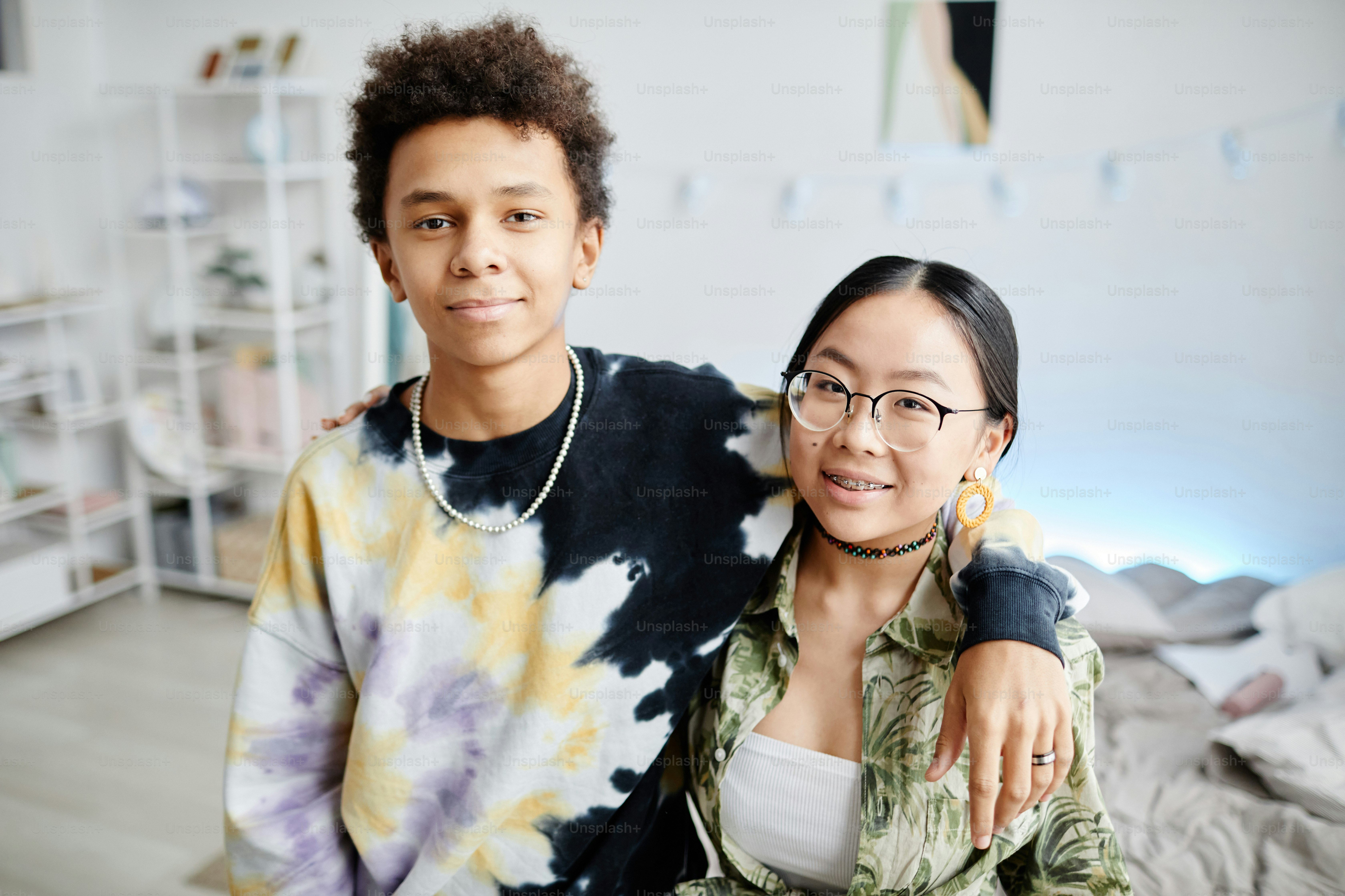 Waist up portrait of two gen Z teenagers, boy and girl smiling at ...