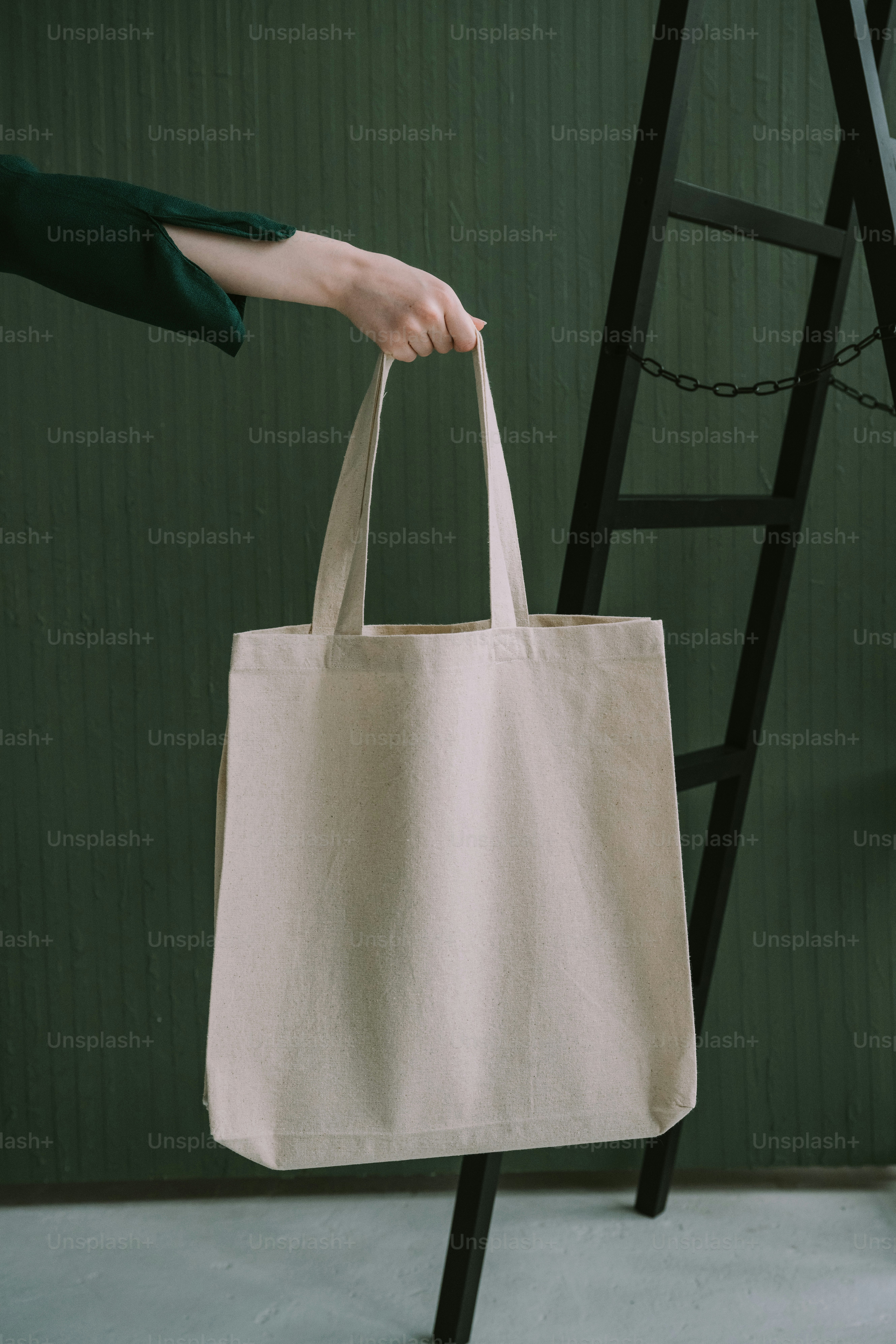 A person holding a white bag in their hand photo – Tote bag Image on ...