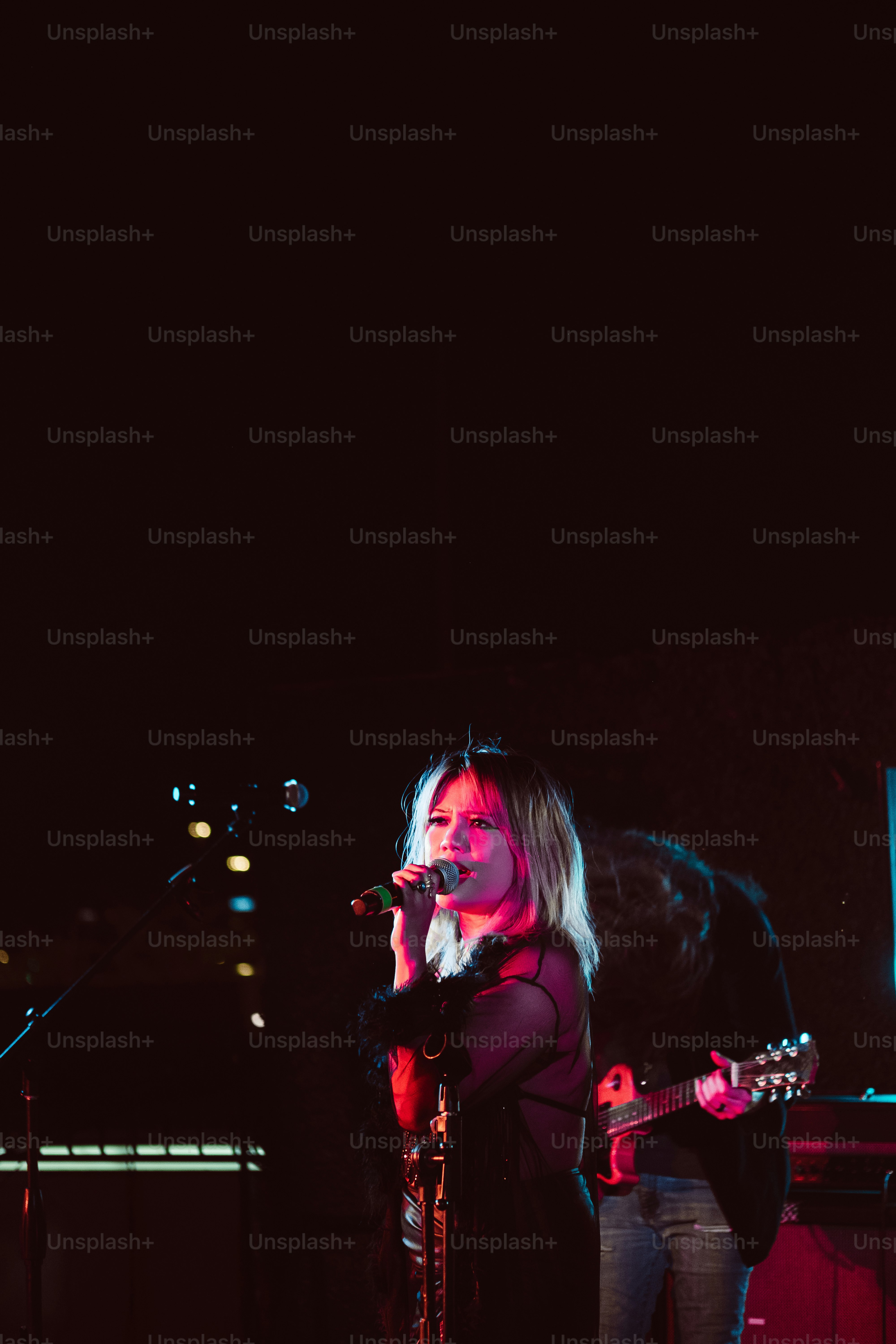 A woman on stage singing into a microphone photo – Rock and roll Image ...