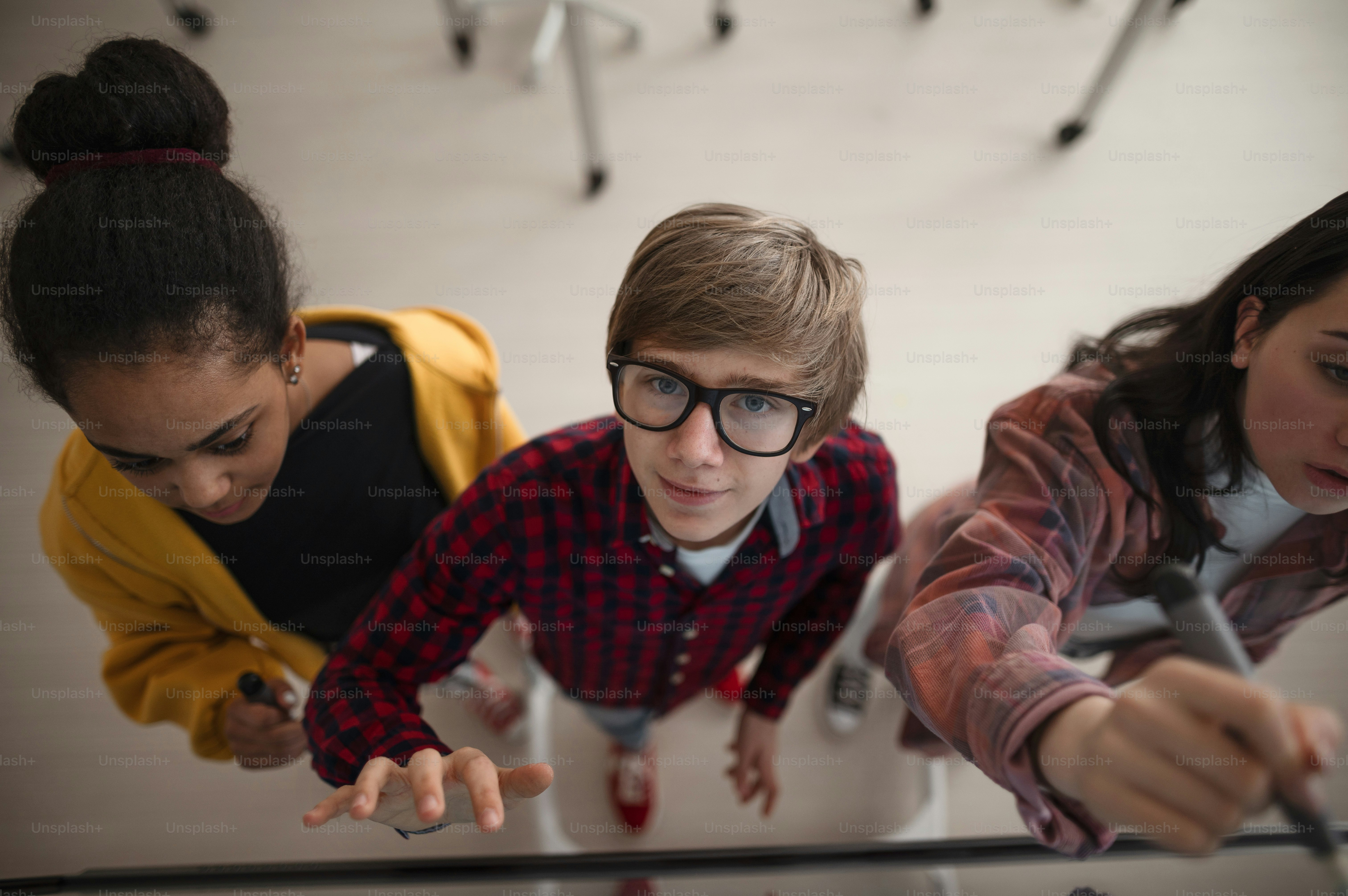 Top view of happy students writing at board in school class. photo ...