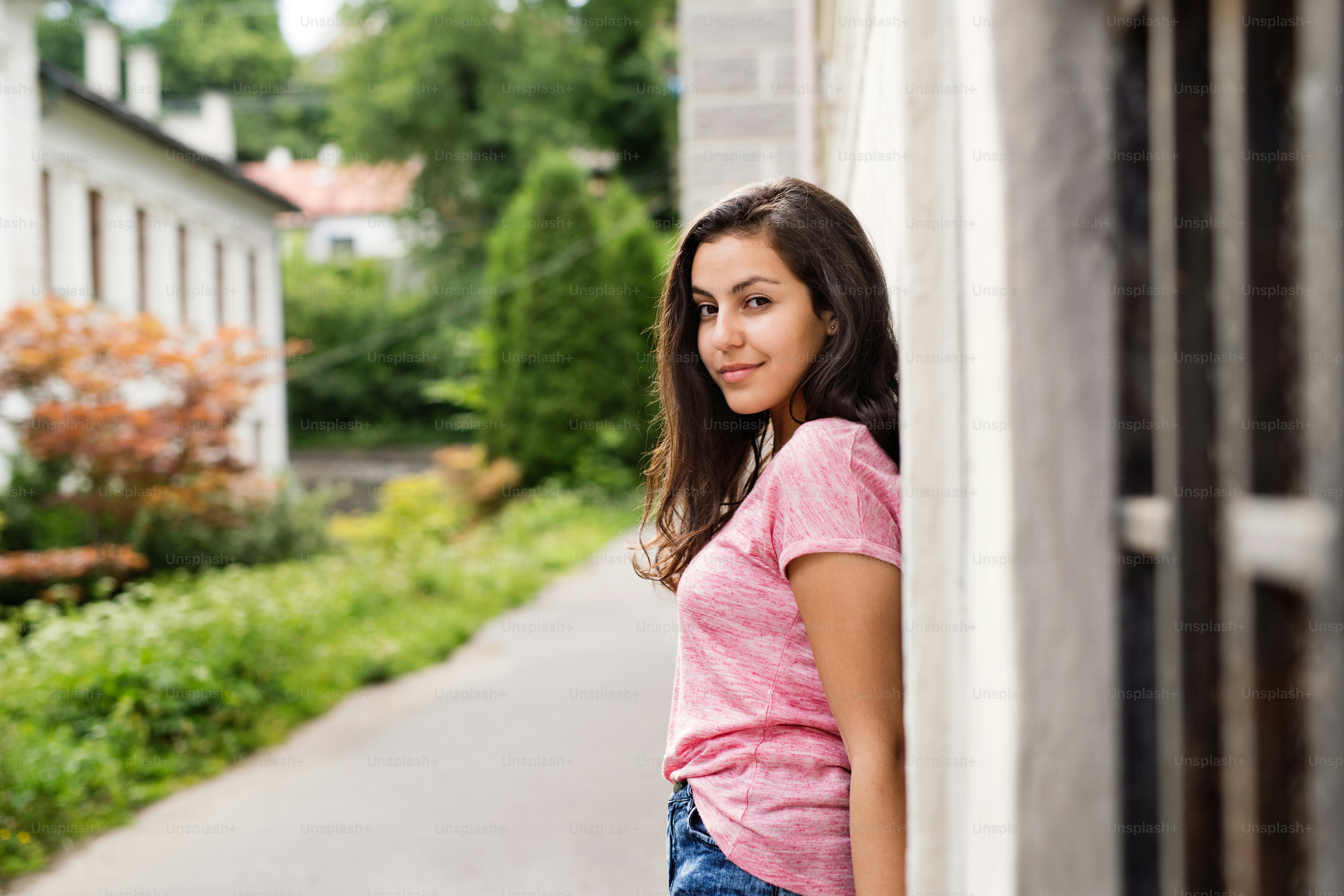 Beautiful teenage student outdoors standing at the concrete wall. photo ...