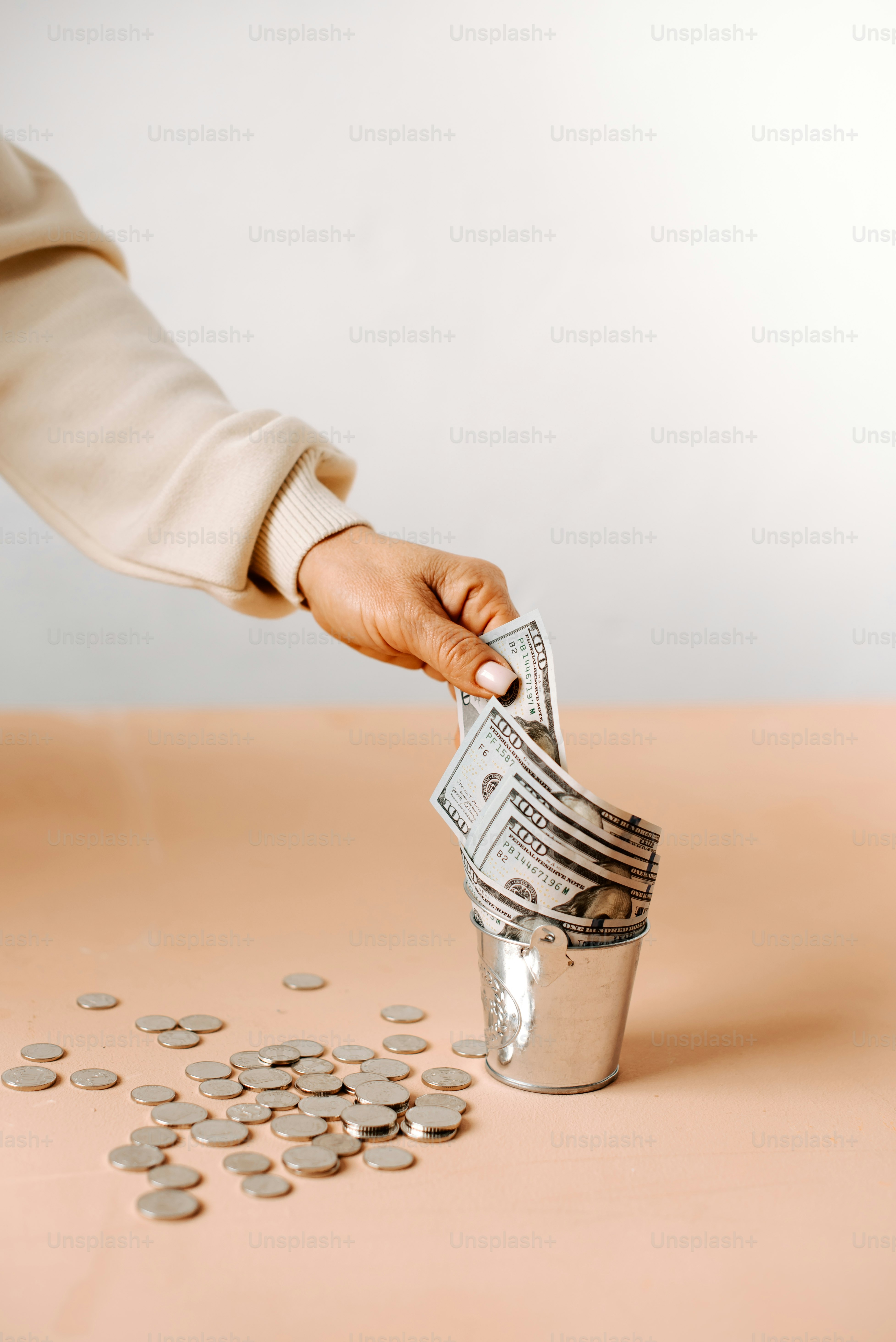 A person putting coins into a bucket photo – Financial Image on Unsplash