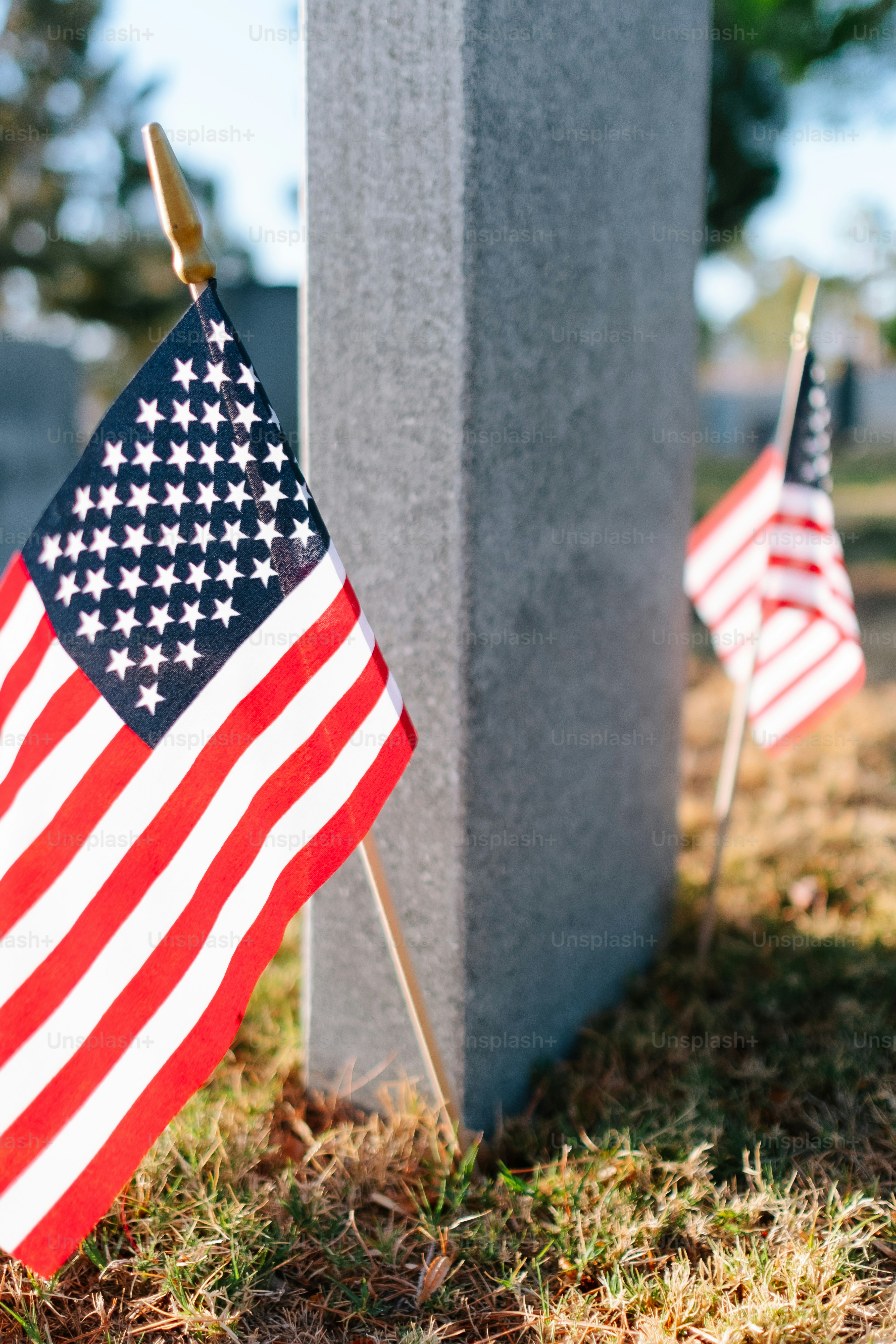 Two american flags are placed in front of a grave photo – American flag ...