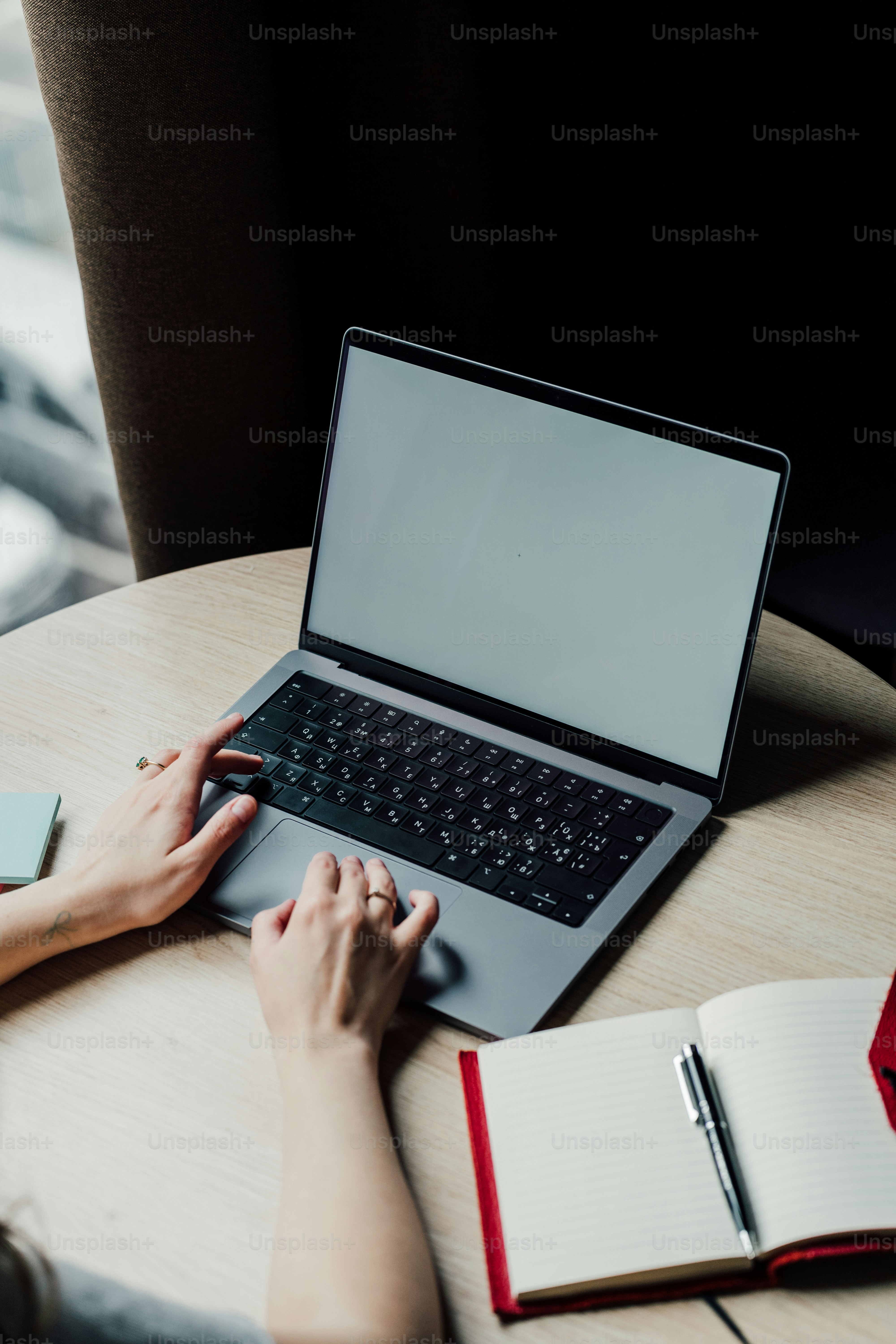 A woman sitting at a table with a laptop computer photo – Website Image ...