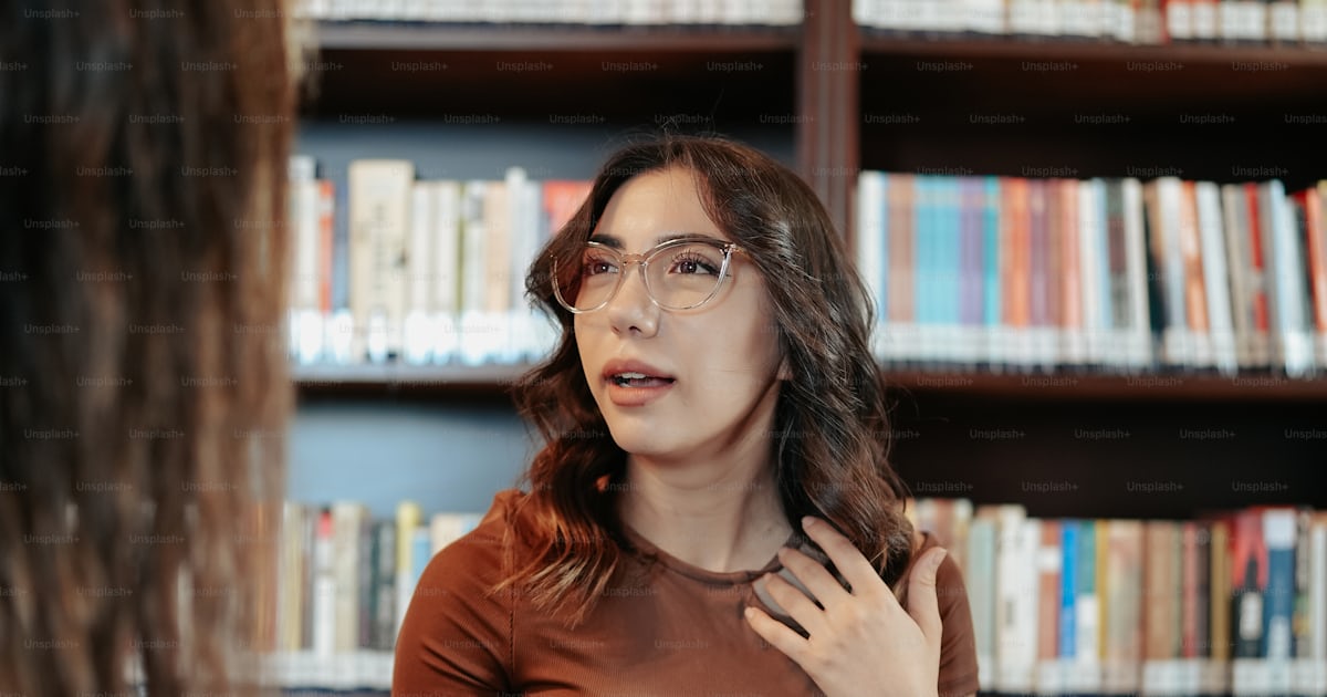 Una Mujer Hablando Con Otra Mujer En Una Biblioteca Foto Imagen De