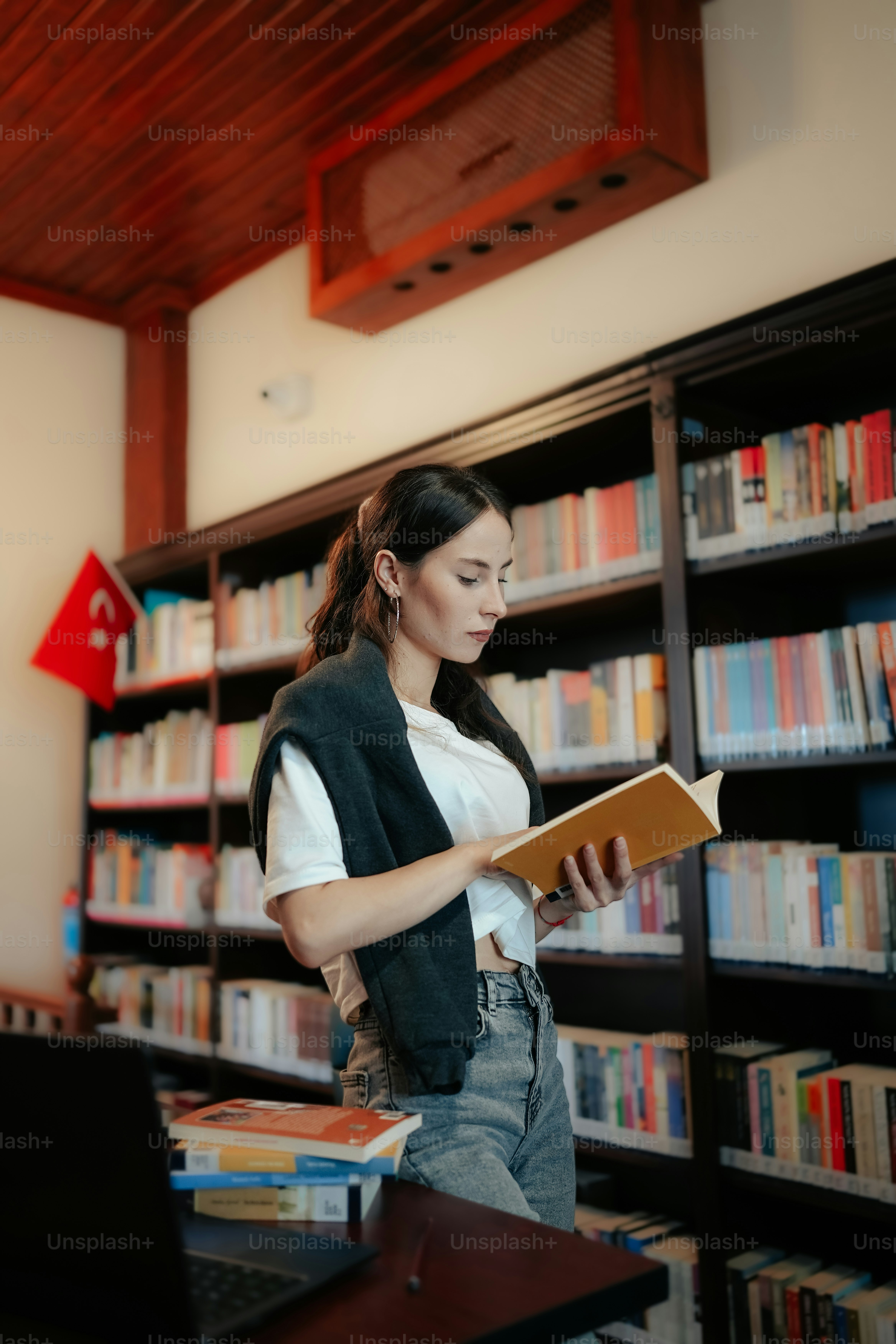 A woman reading a book in a library photo – Student reading Image on ...