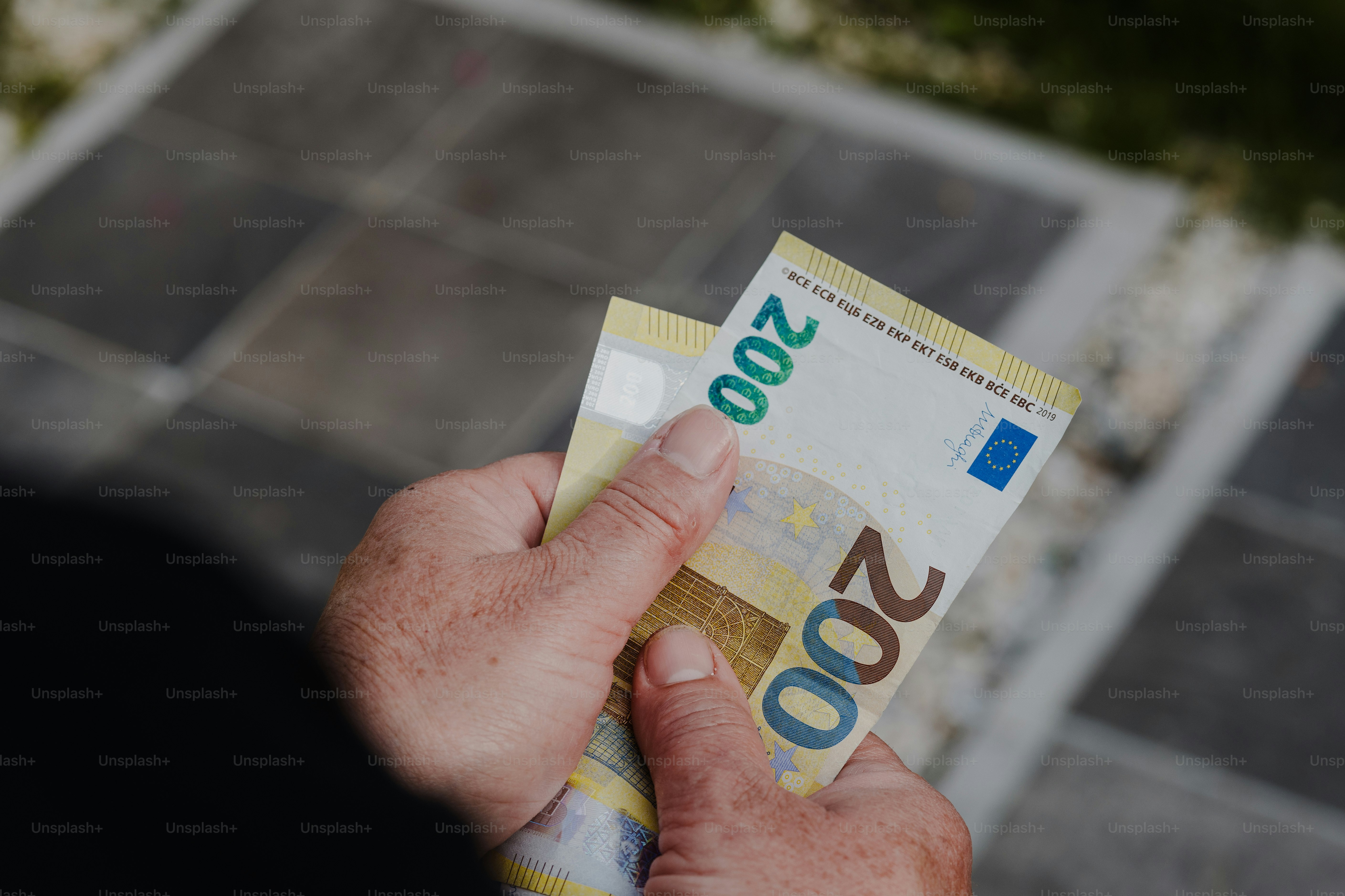 A person holding a bank note in their hand photo – Euro Image on Unsplash