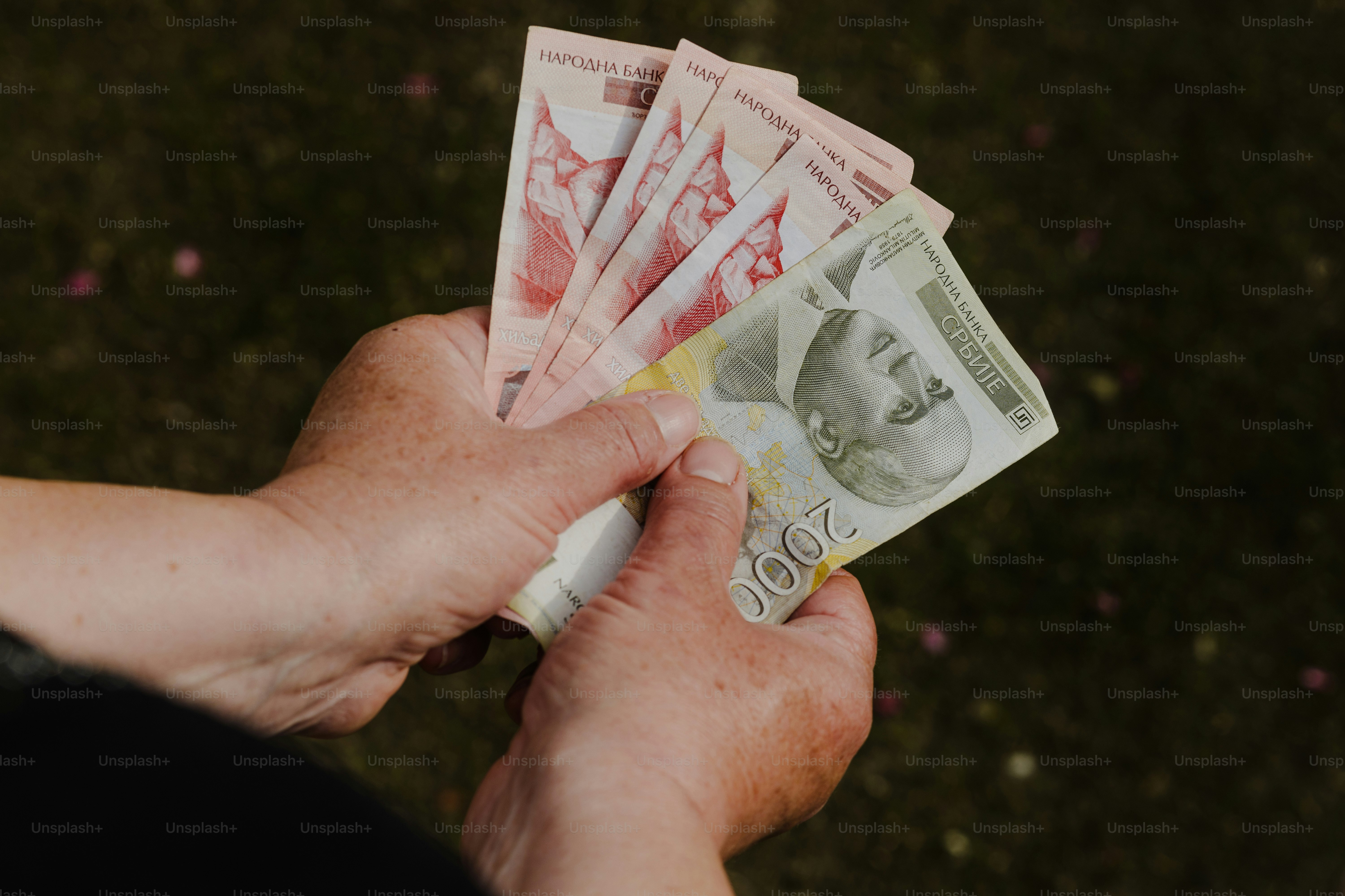 Una persona que sostiene un montón de dinero en la mano foto – Imagen de Dinero en Unsplash