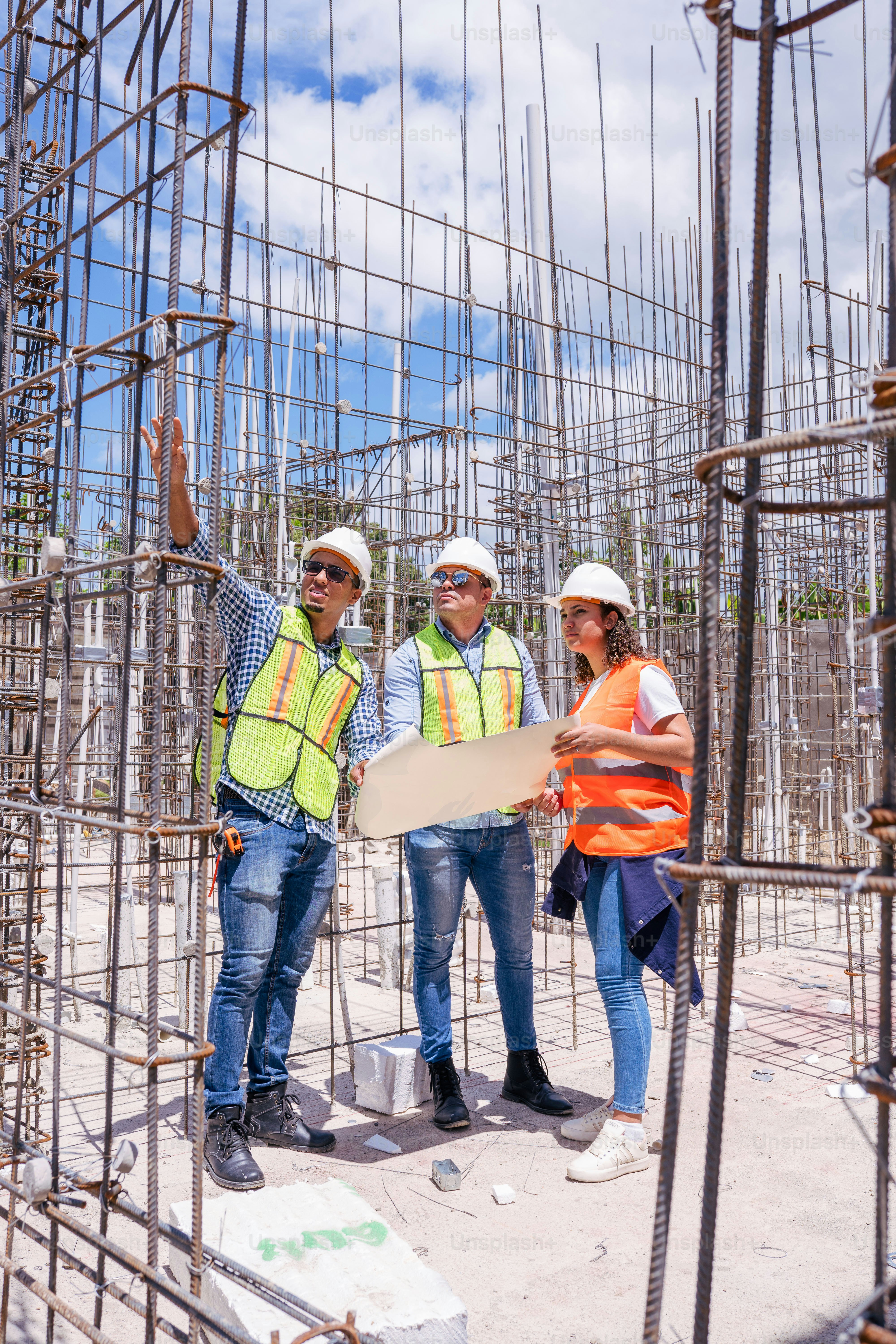 A group of people standing next to each other on a construction site ...