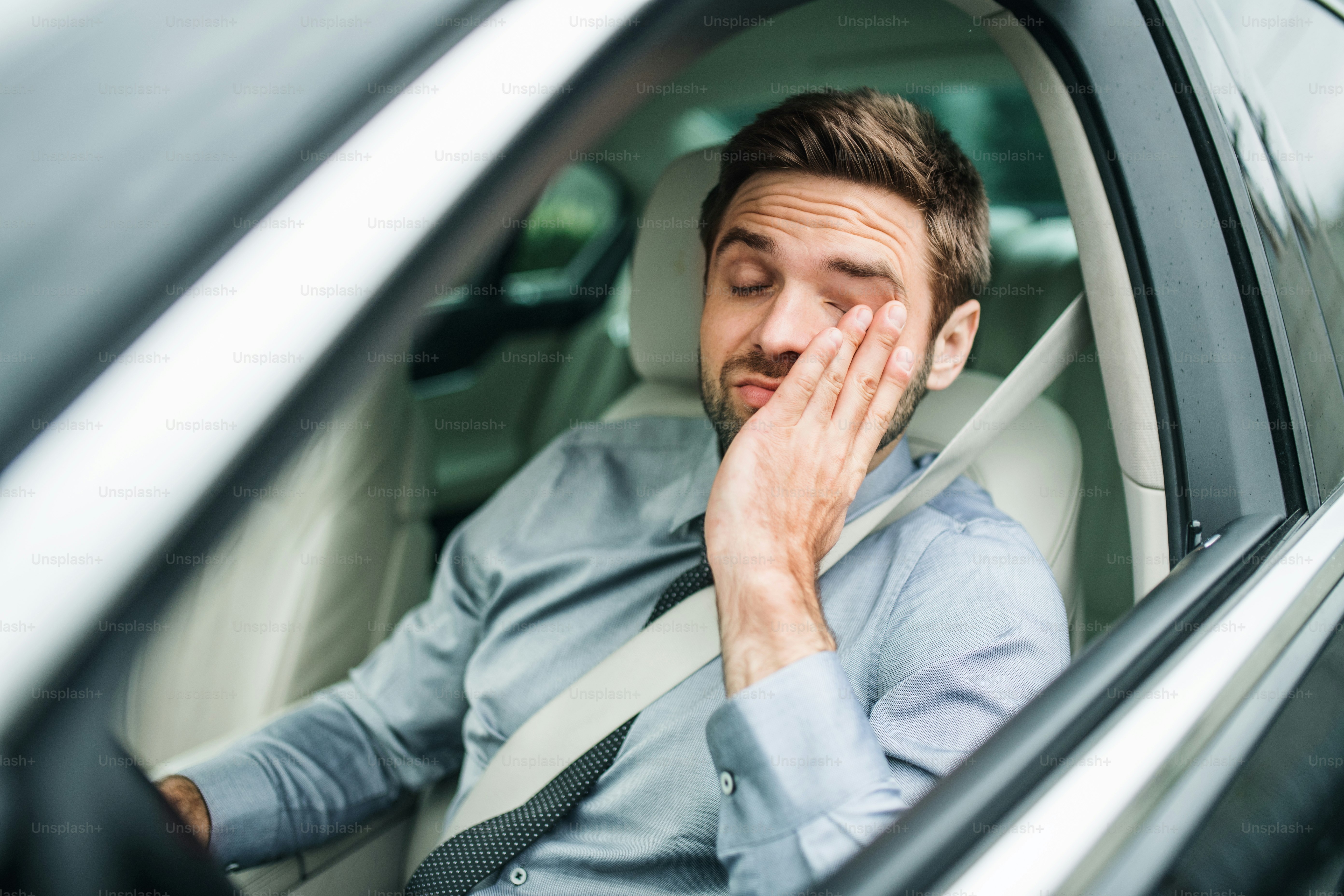 A young bored business man with shirt and tie sitting in car. photo ...