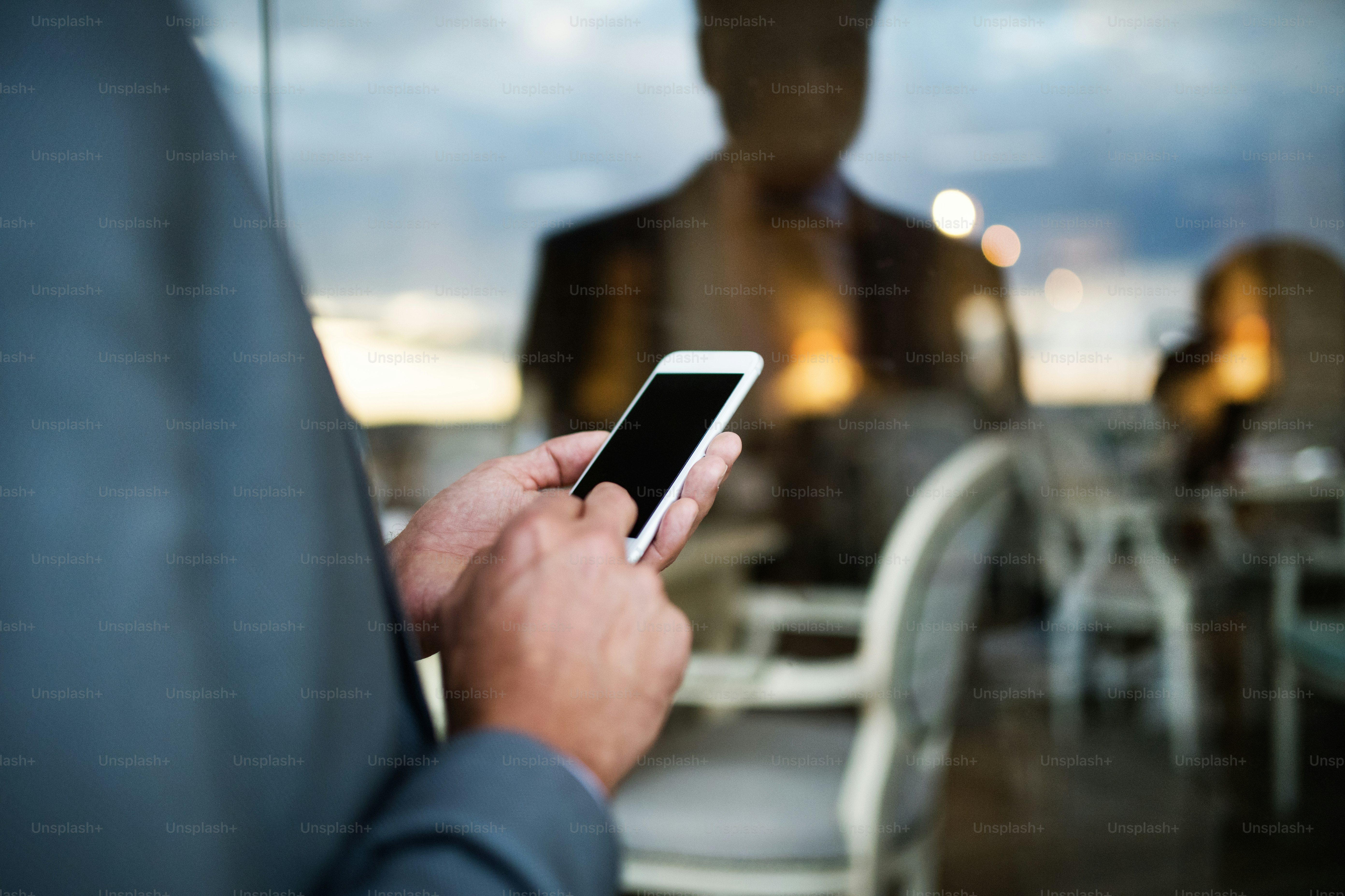 Mature businessman standing at the big windows in a hotel. Man looking ...