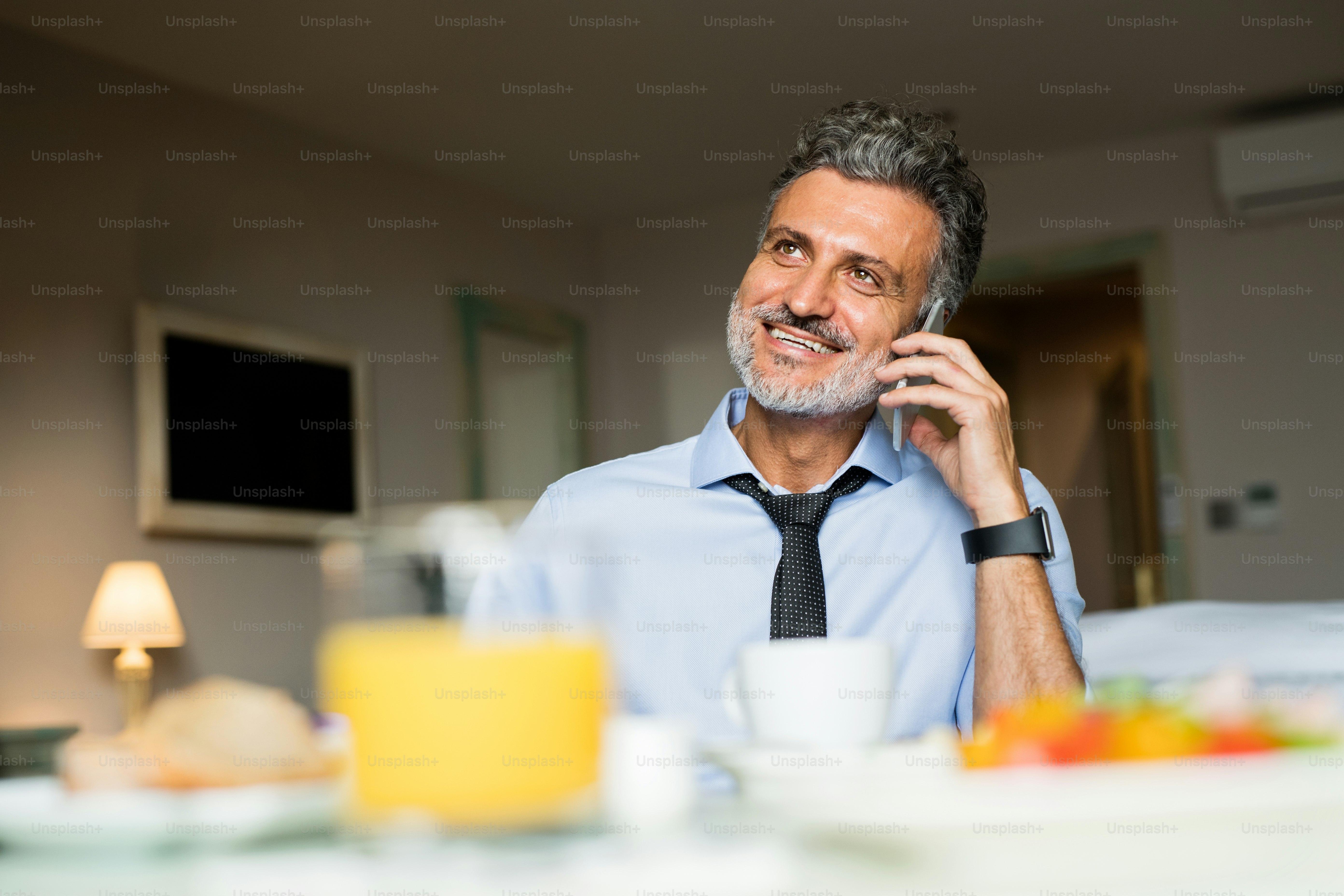 Mature businessman standing at the big windows in a hotel. Man looking ...