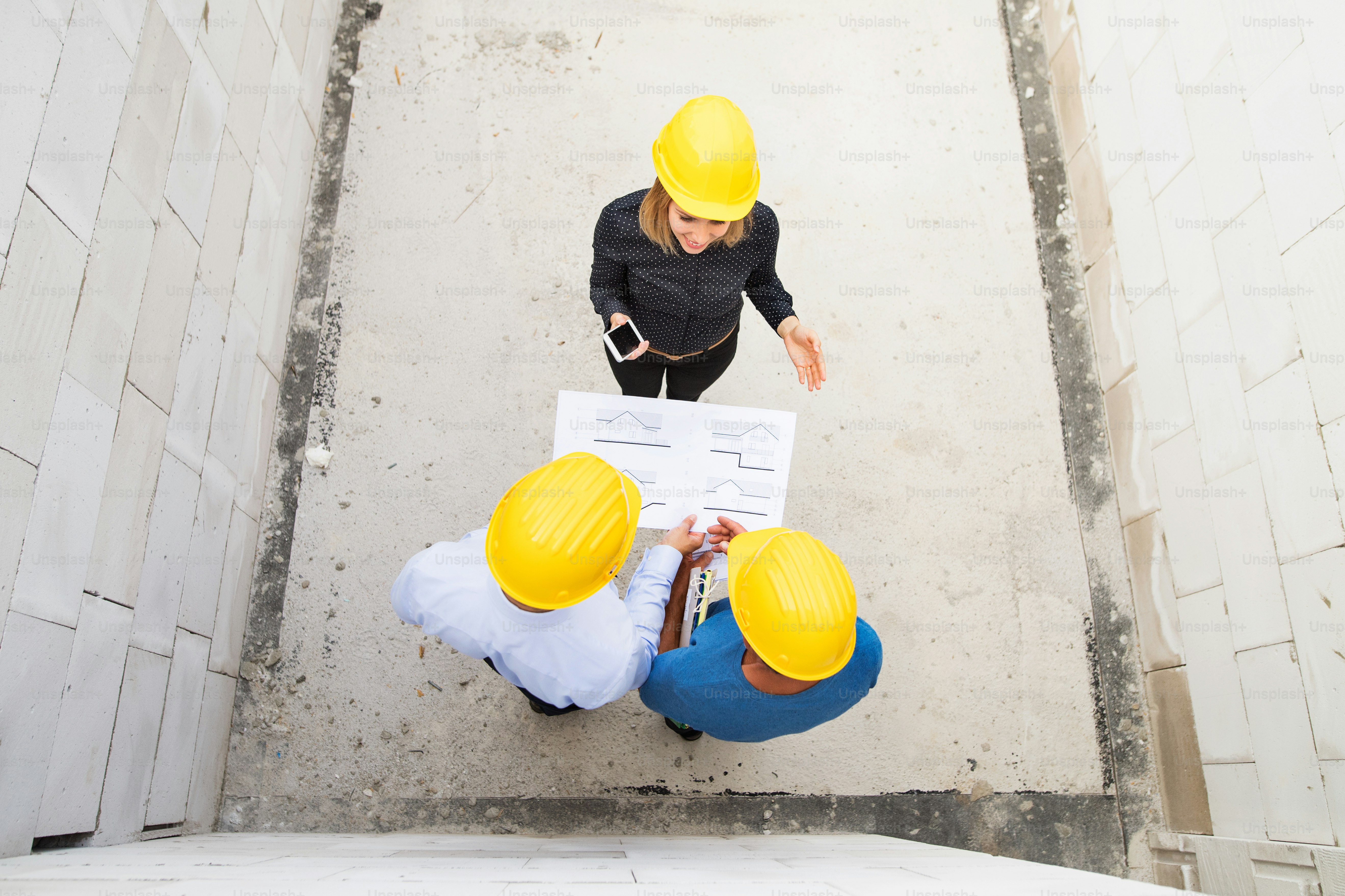 Architect Civil Engineer And Worker Looking At Plans And Blueprints