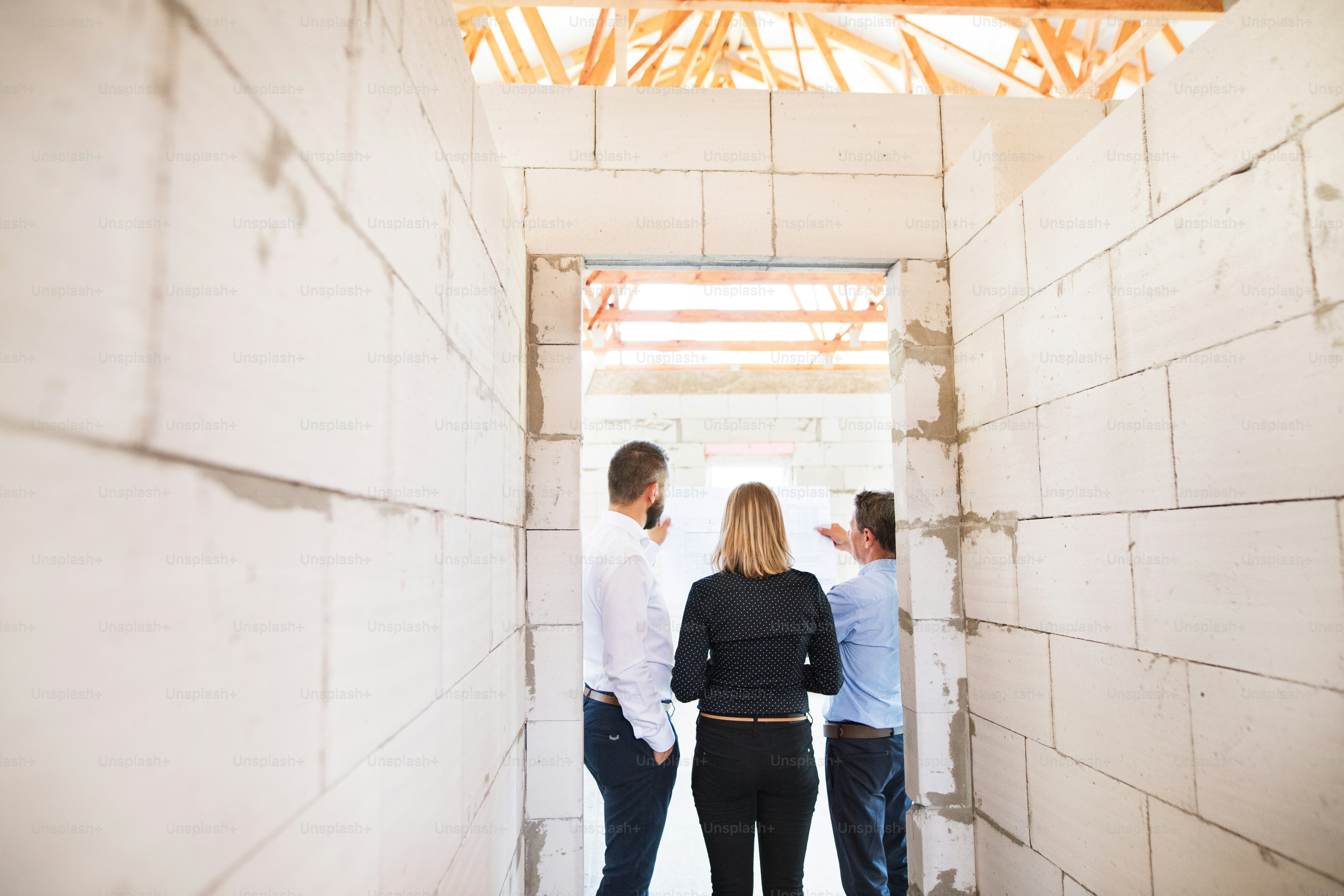 Architect, civil engineer and worker looking at plans and blueprints ...