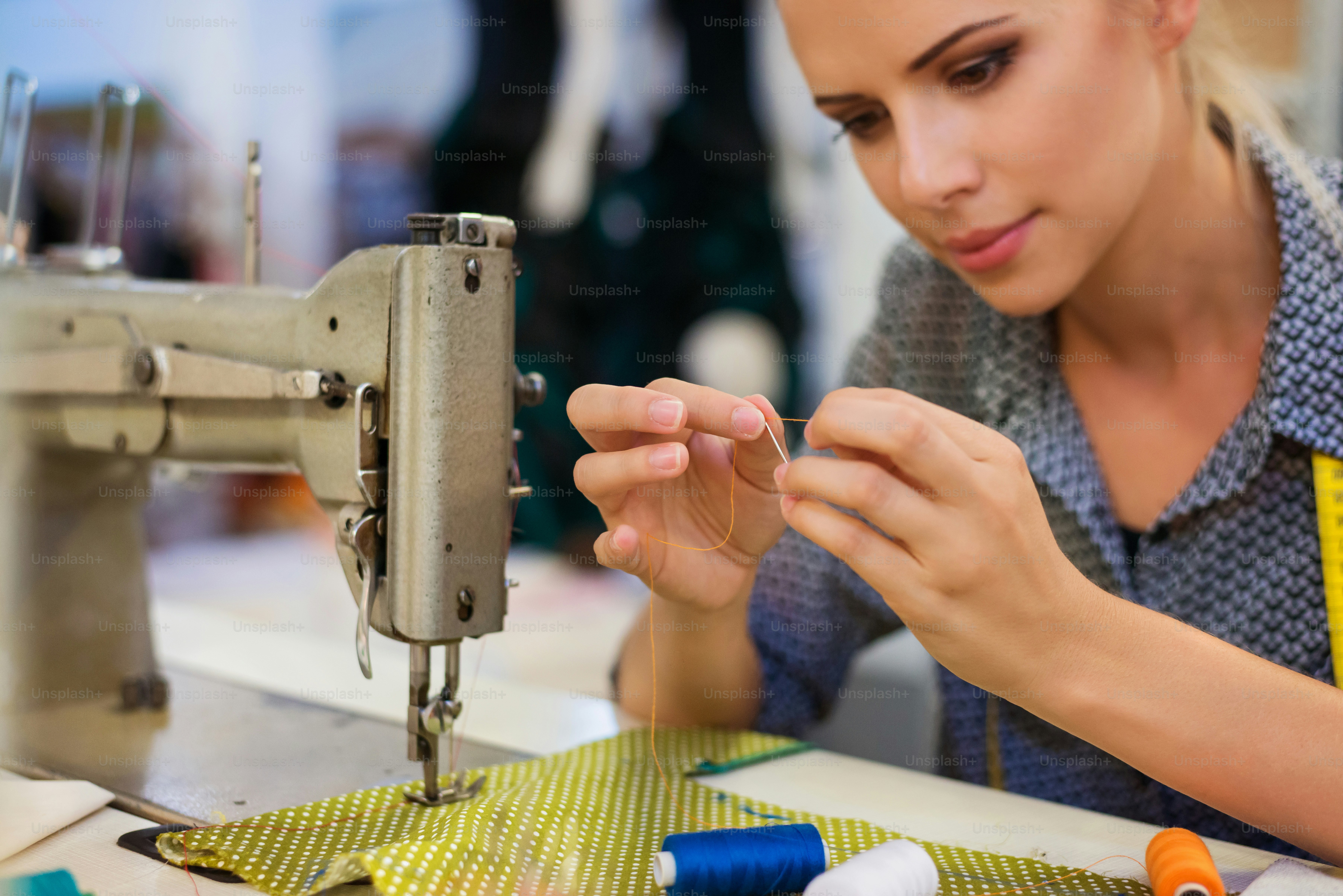 Beautiful young woman sewing clothes with sewing machine. photo ...