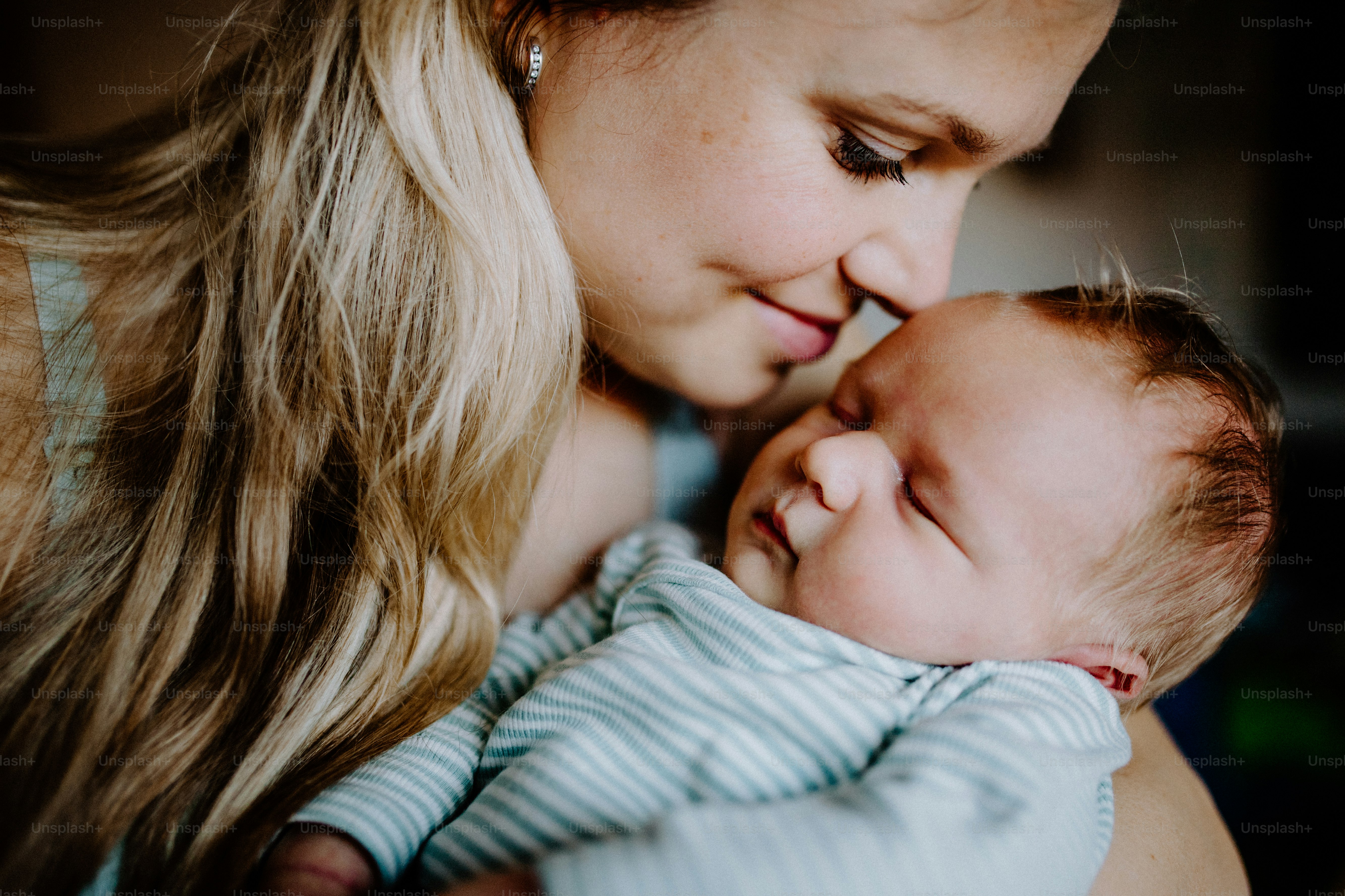 A beautiful young mother holding a newborn baby at home. photo ...