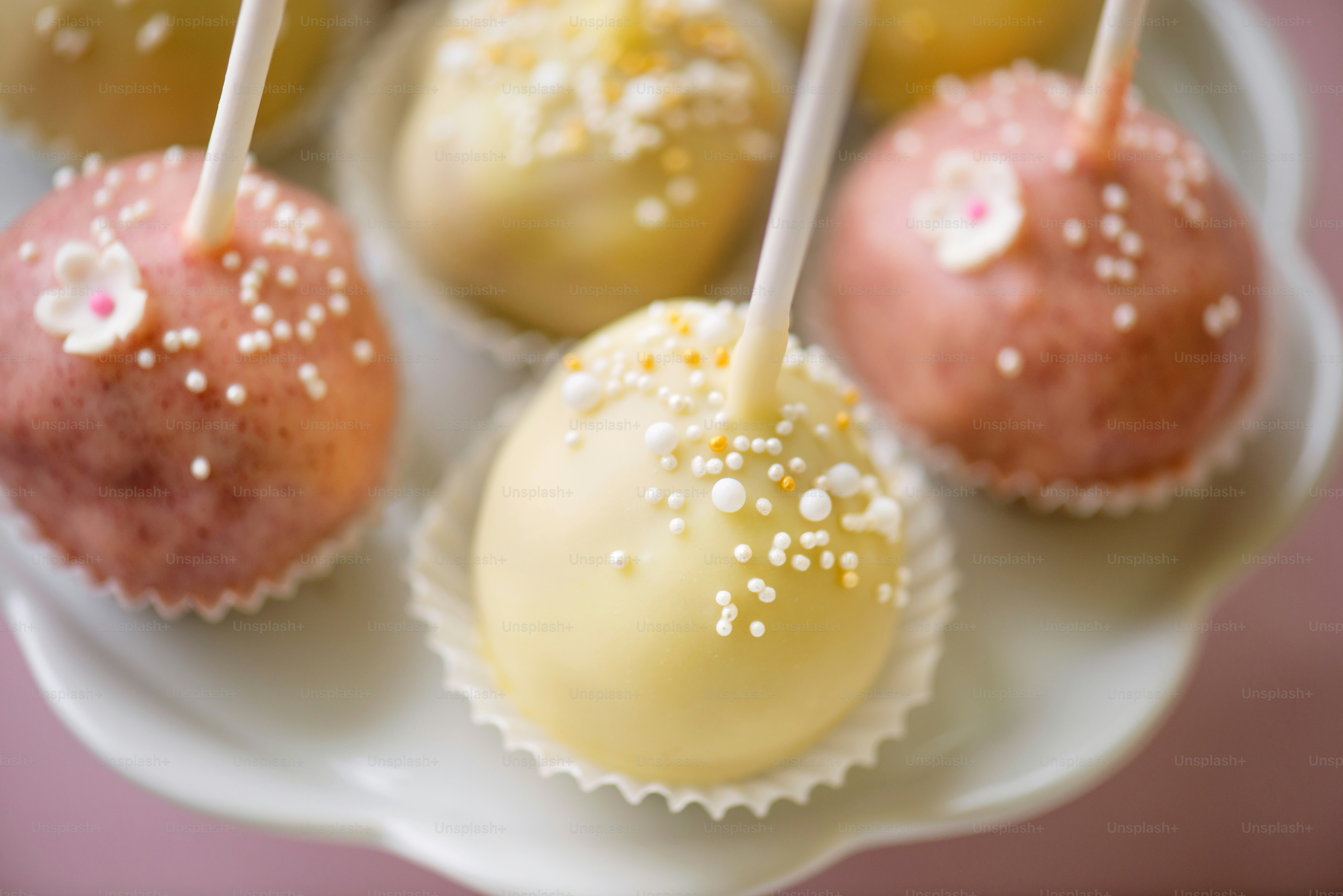 Table with white and pink cake pops on cakestand, close up. Candy bar ...