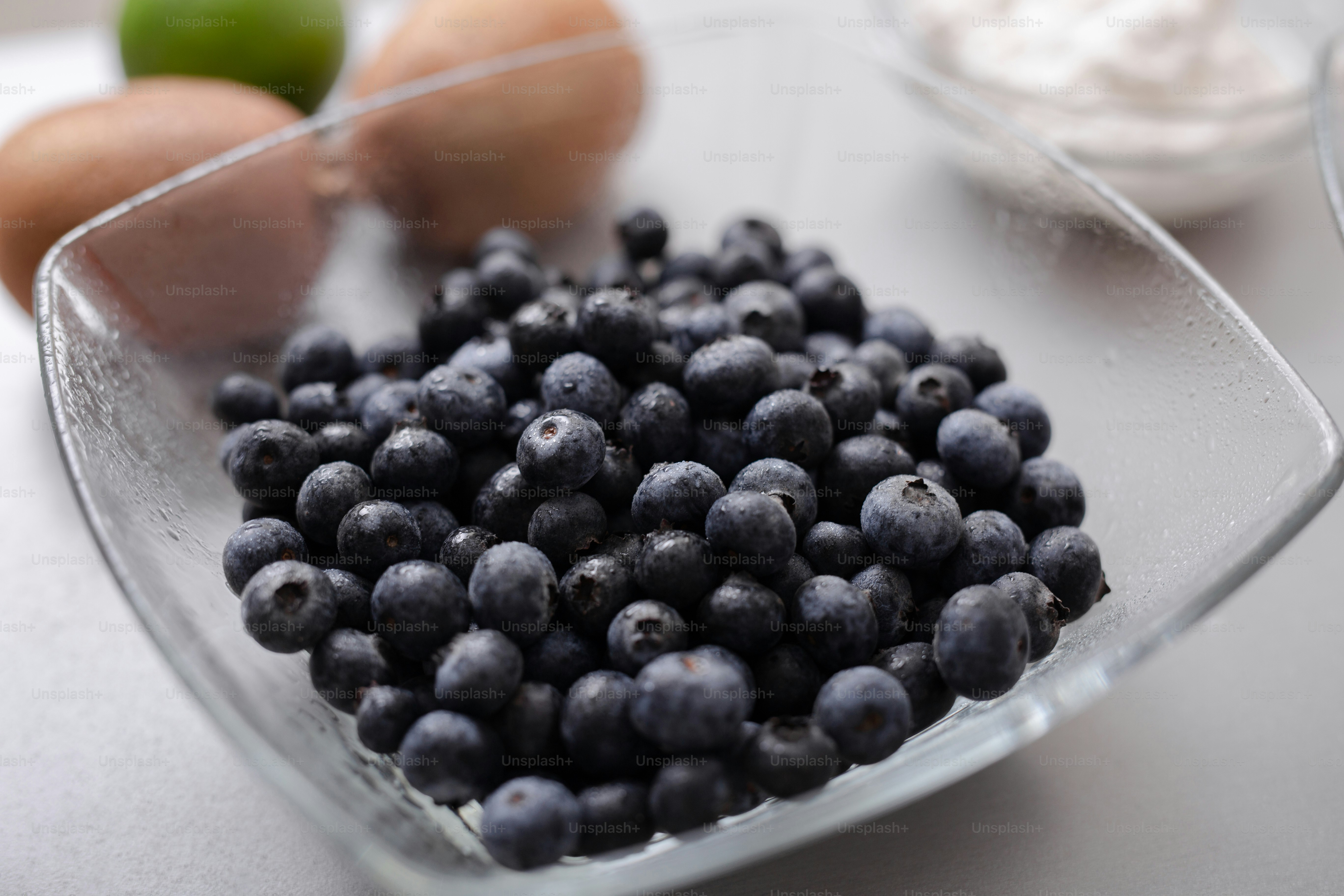 Fresh blueberries in a glass bowl on kitchen counter, healthy food for ...