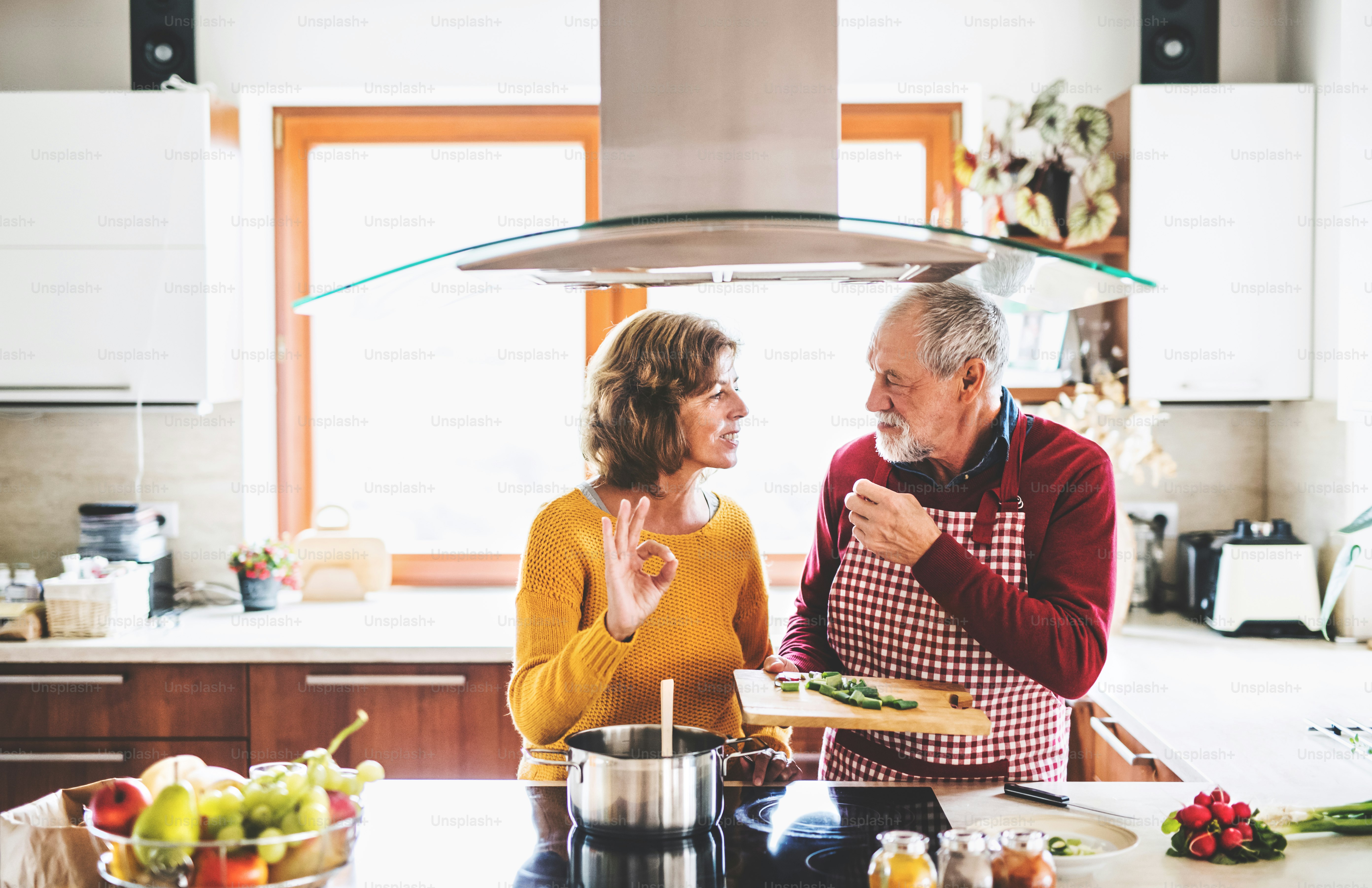 Senior couple preparing food in the kitchen. An old man and woman ...