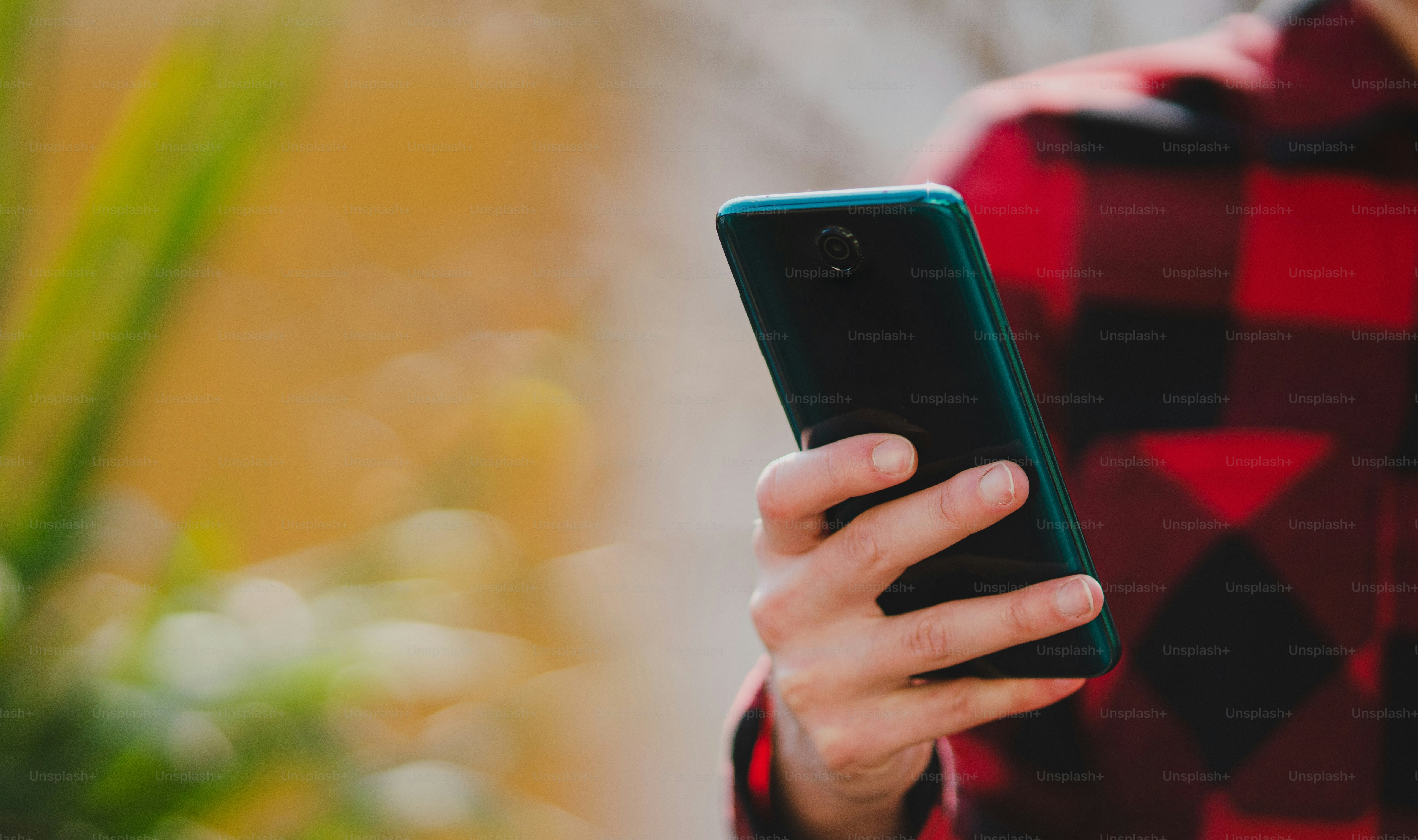 A close up of woman hand using smartphone, outdoors in park. Copy space ...
