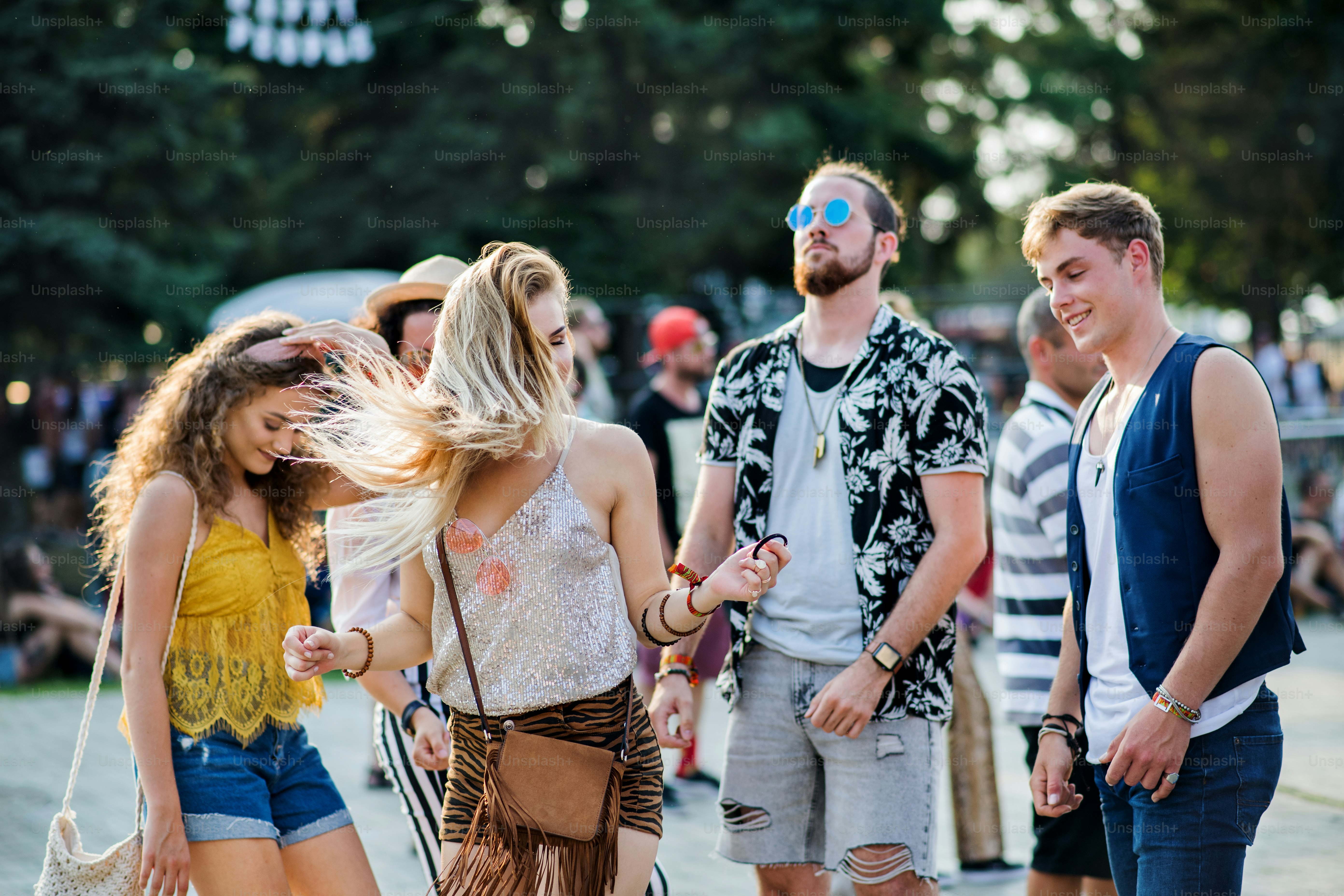 A front view portrait of group of young friends dancing at summer ...