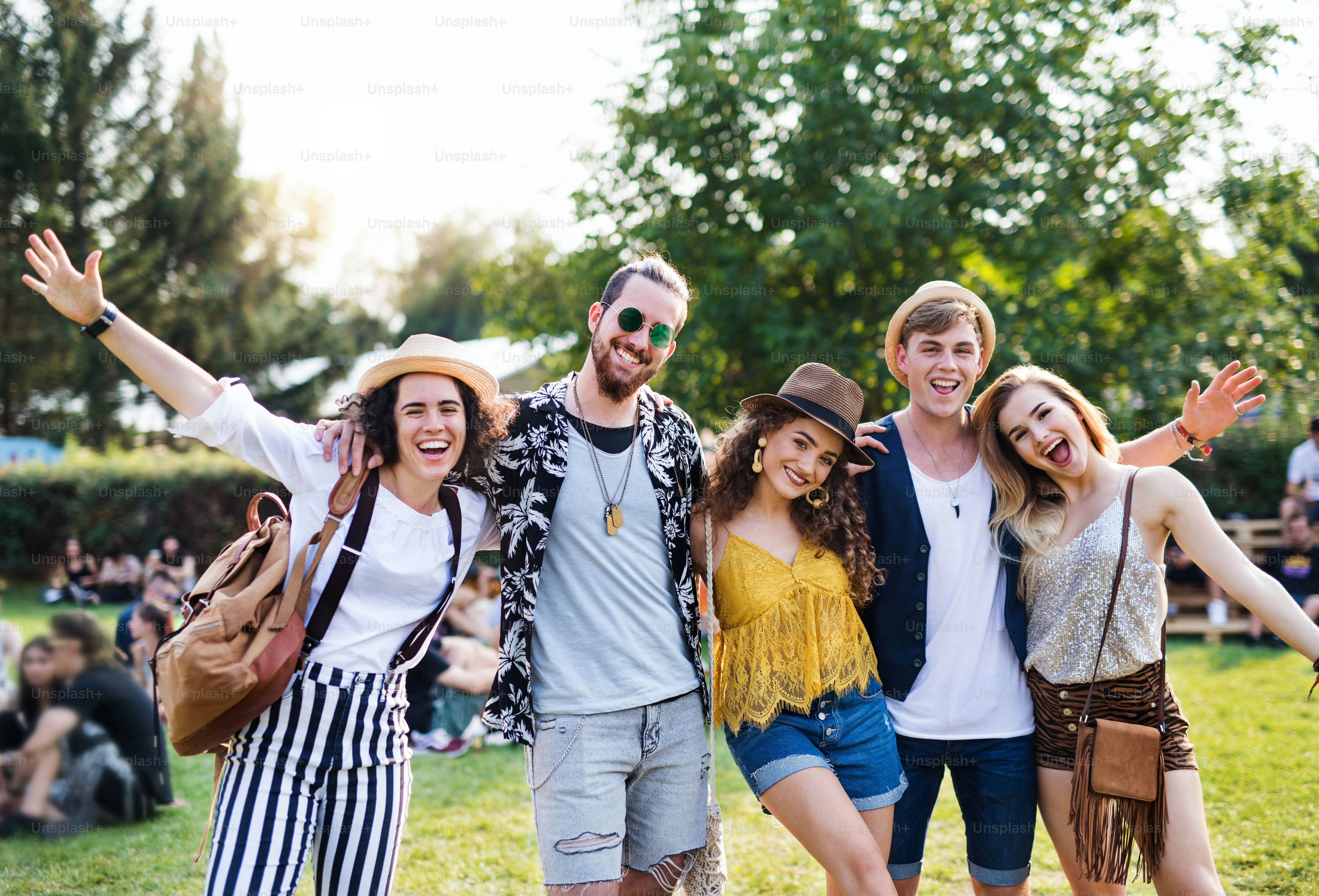 Rear view of group of unrecognizable young friends dancing at summer ...