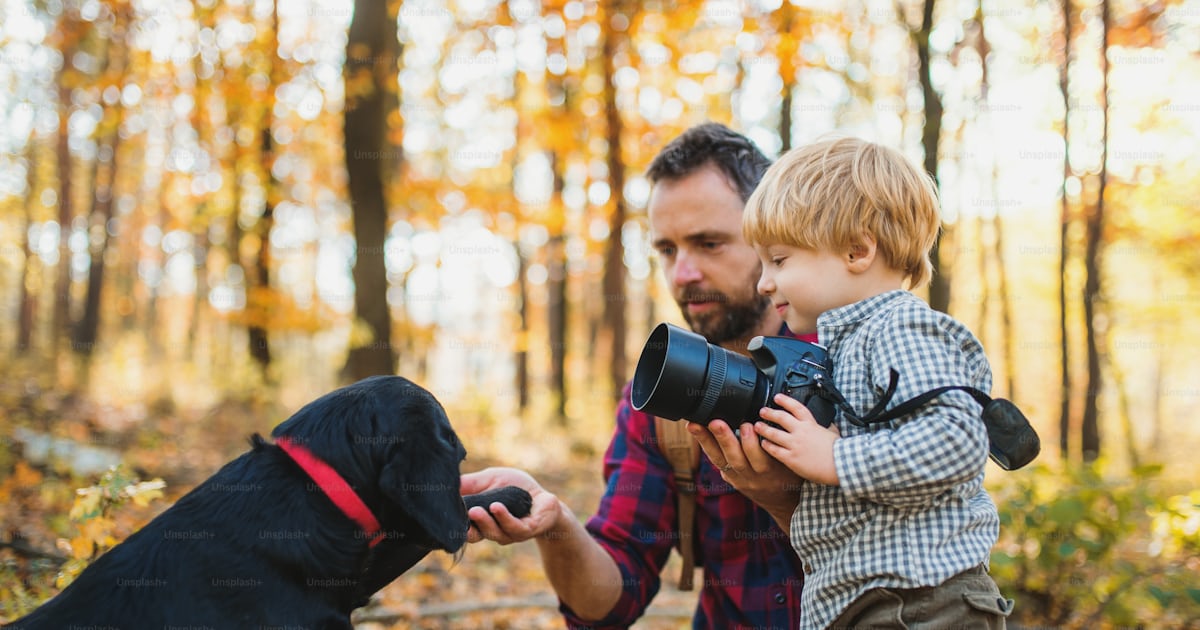 Un Père Mûr Avec Un Chien Et Un Fils En Bas âge Avec Un Appareil Photo