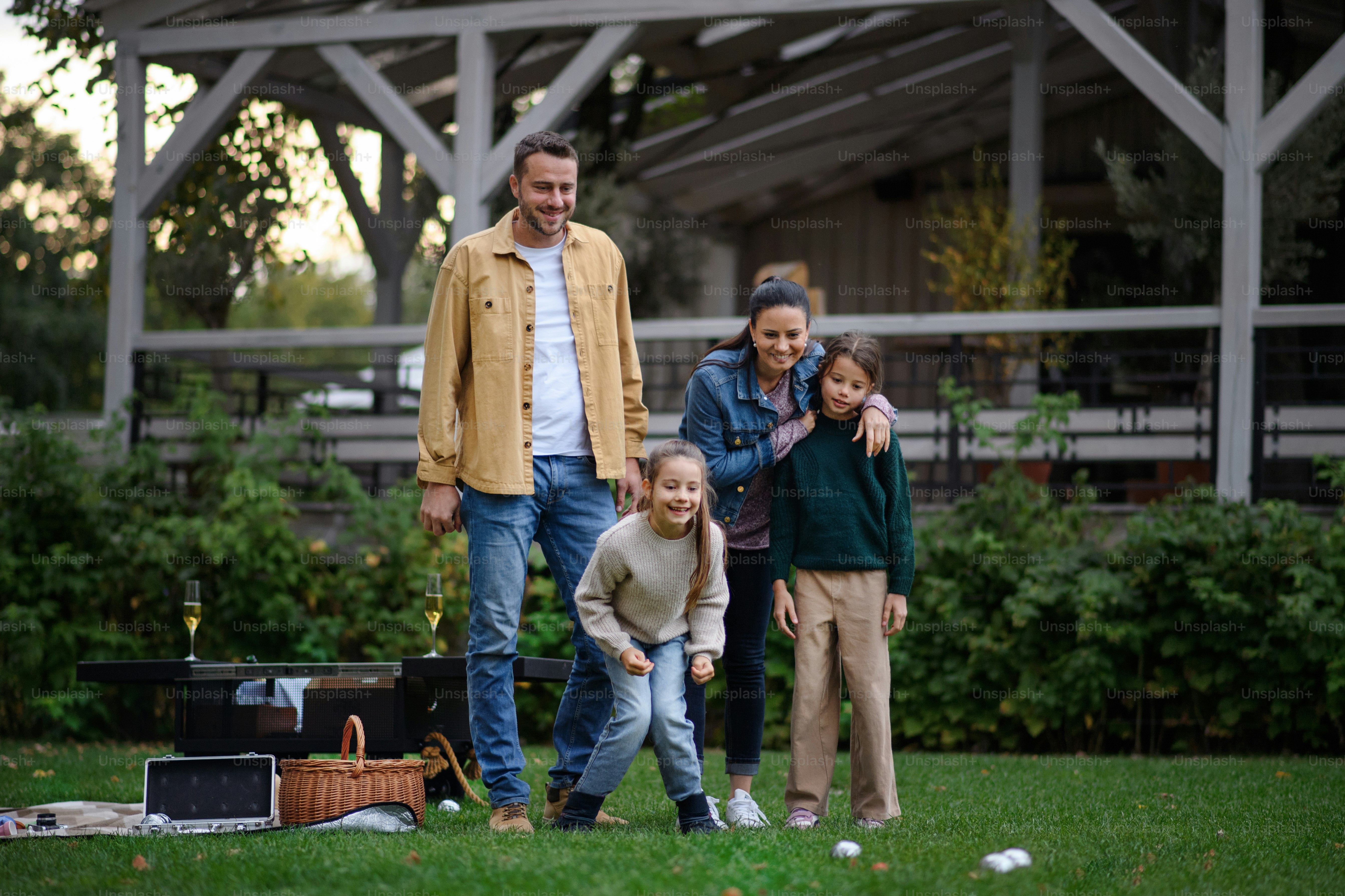 A happy young family with basket and blanket going to have picnic ...