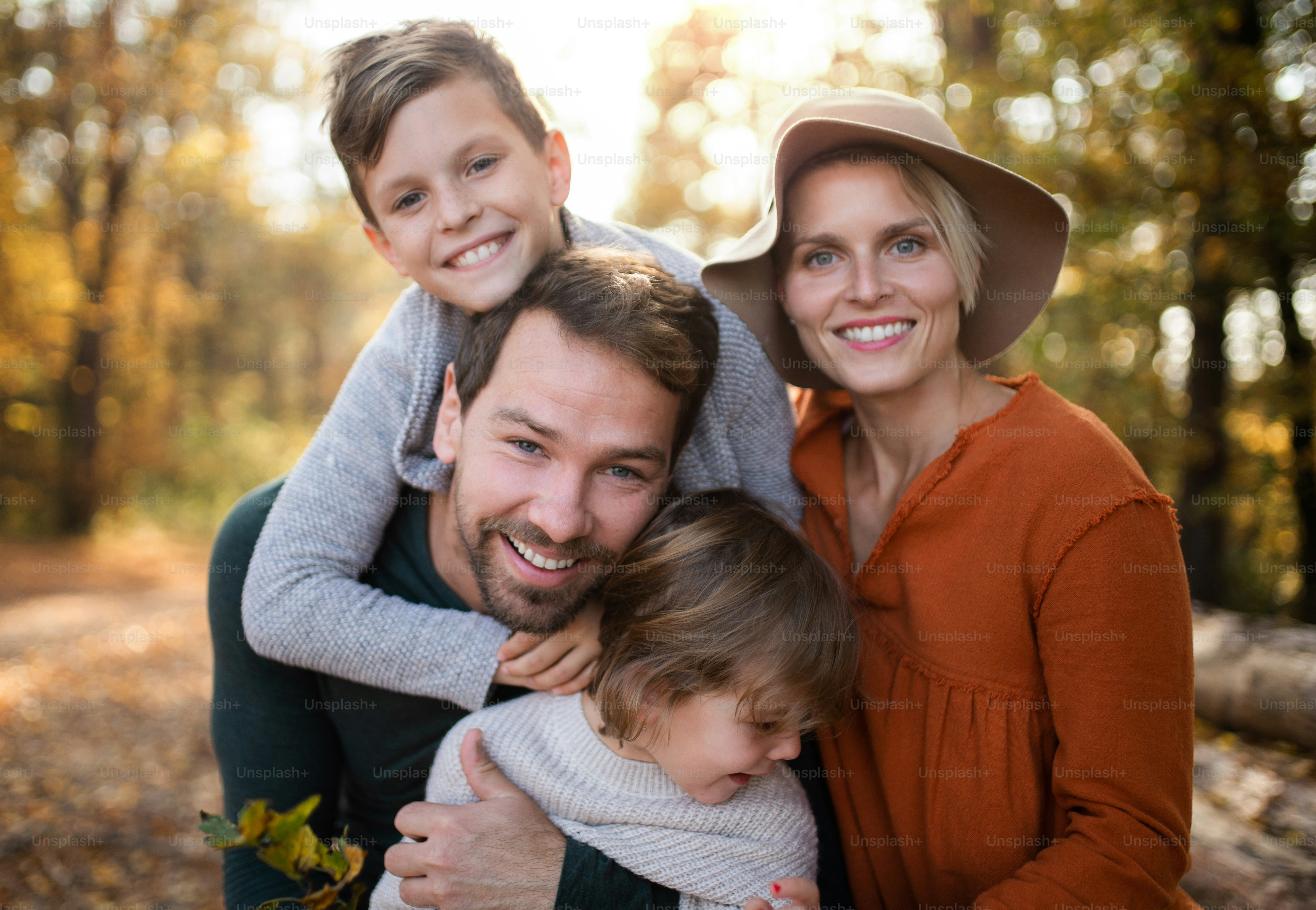 A beautiful young family with small children on a walk in autumn forest ...