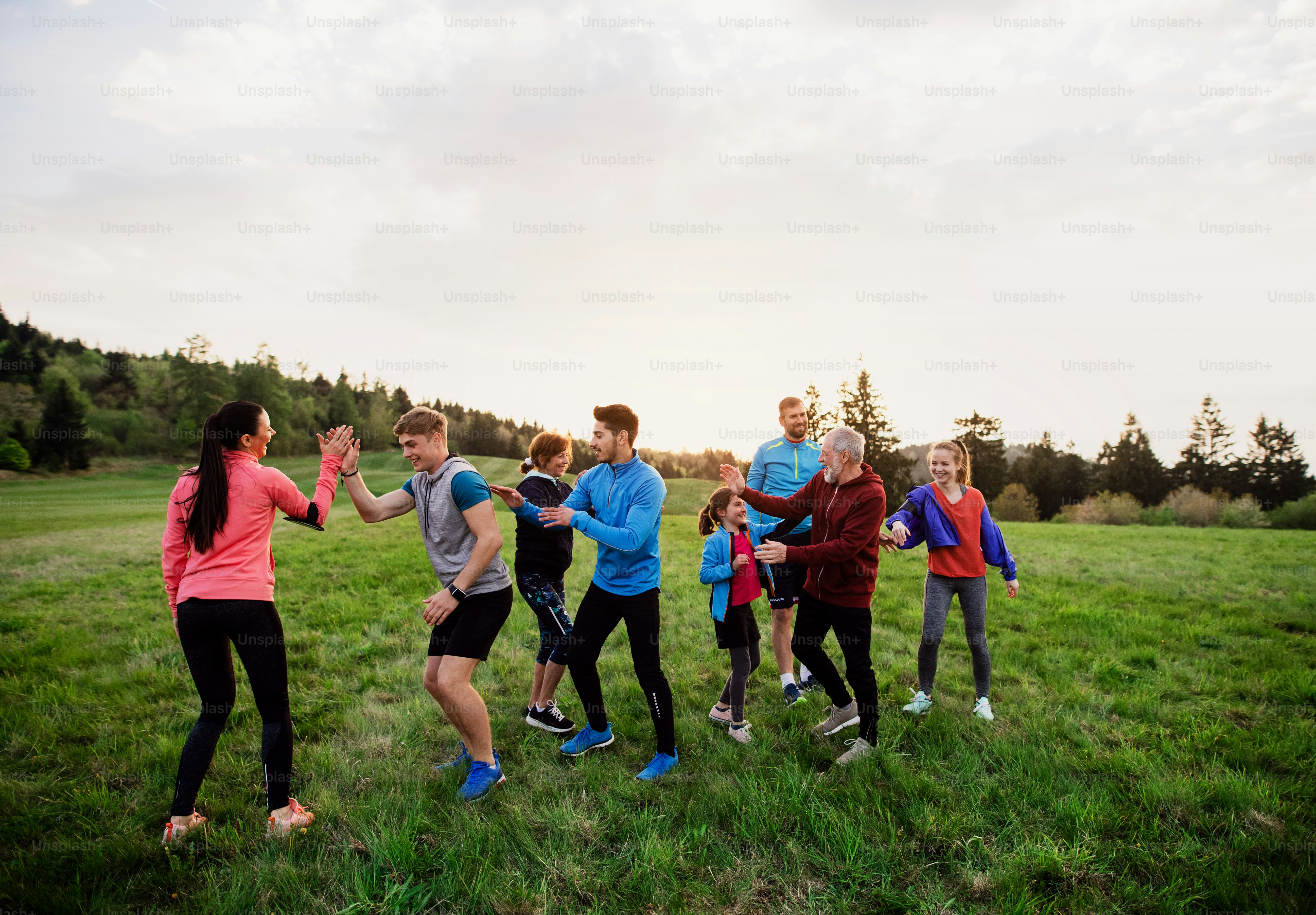 A large group of fit and active people resting after doing exercise in ...