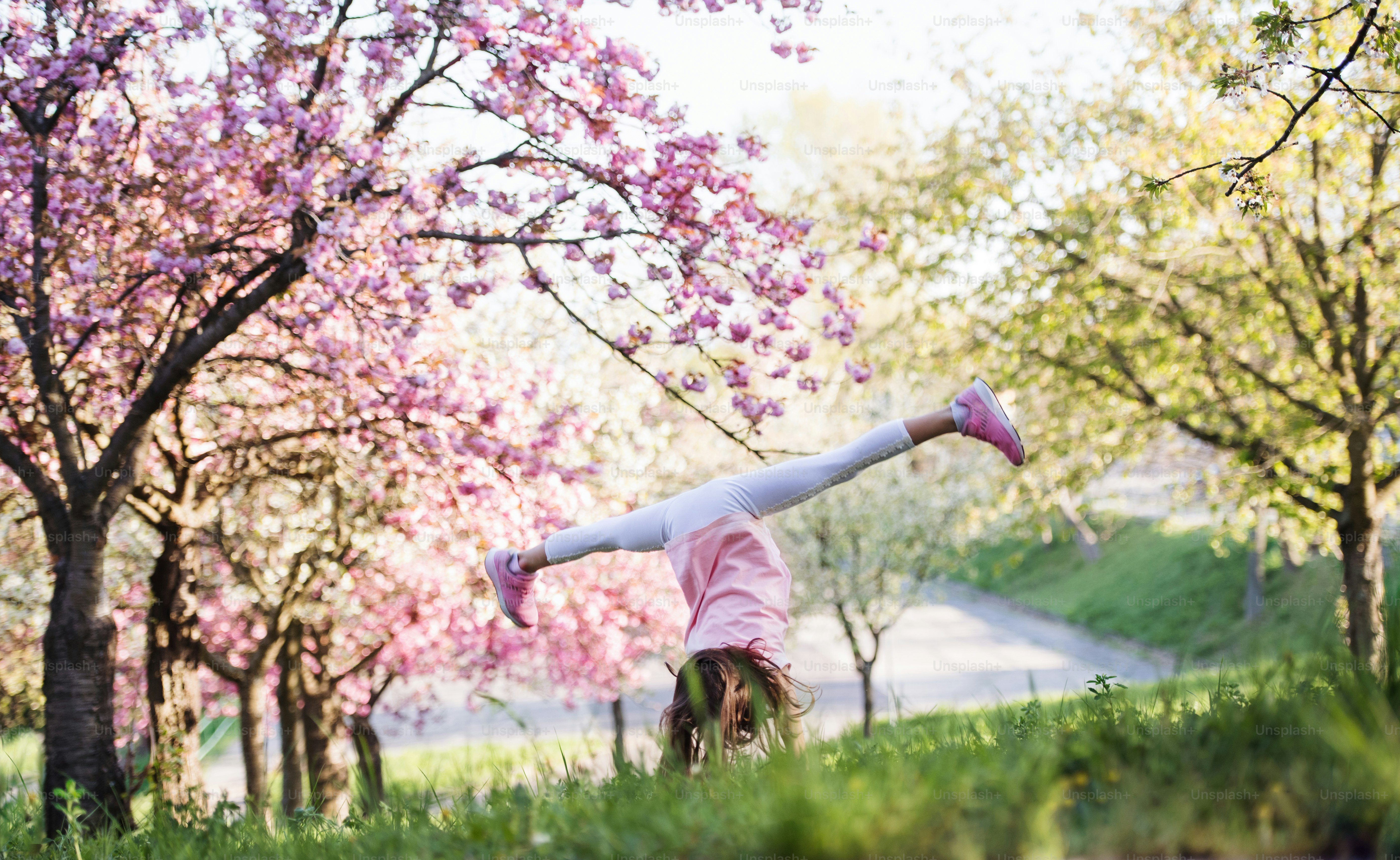 A cheerful small girl playing outside in spring nature. photo ...