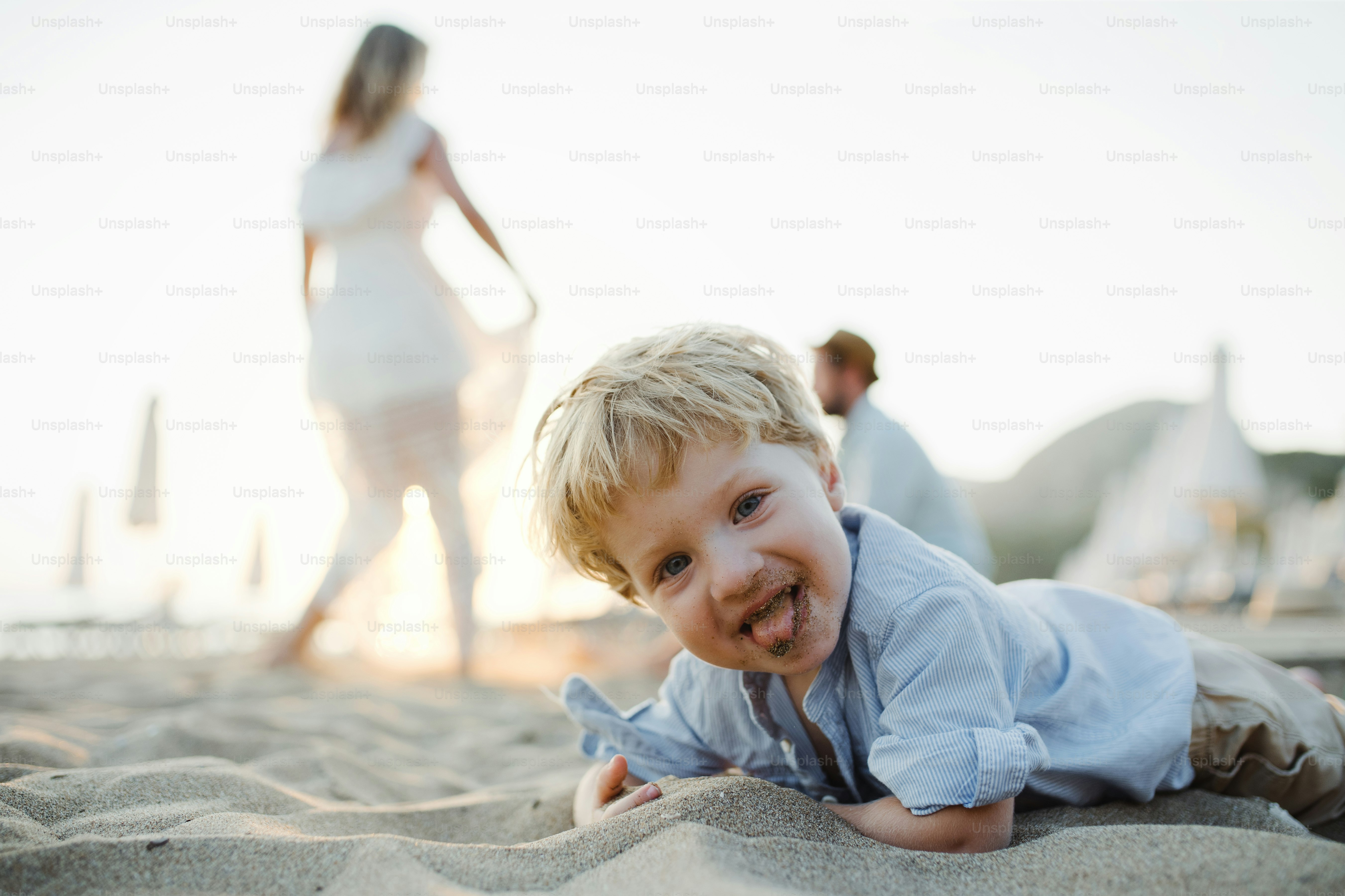Two shirtless toddler children walking on a beach on summer holiday ...