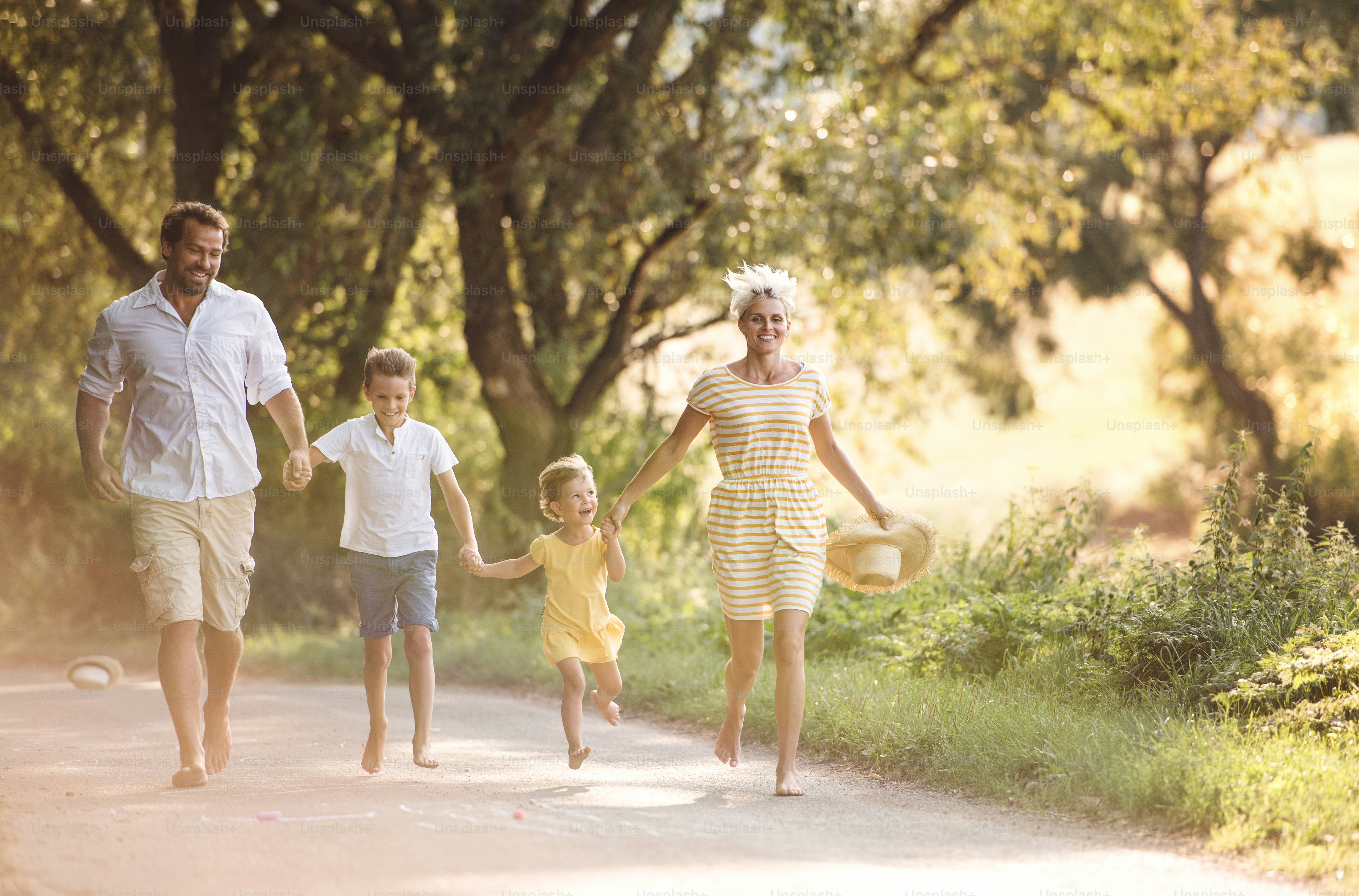 Foto zum Thema Eine junge Familie mit kleinen Kindern, die barfuß auf ...