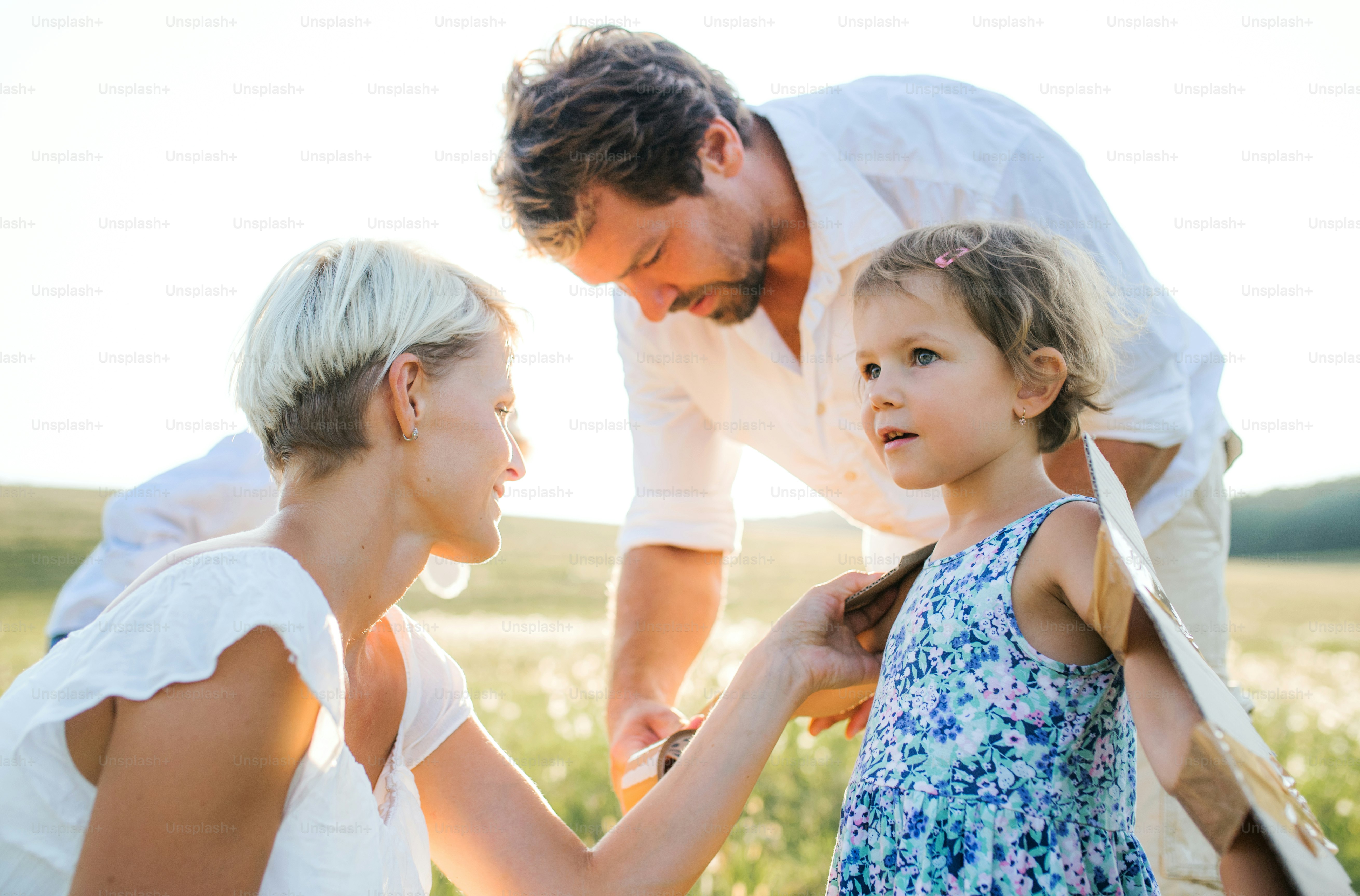A young family with small children playing on a meadow in nature. photo ...