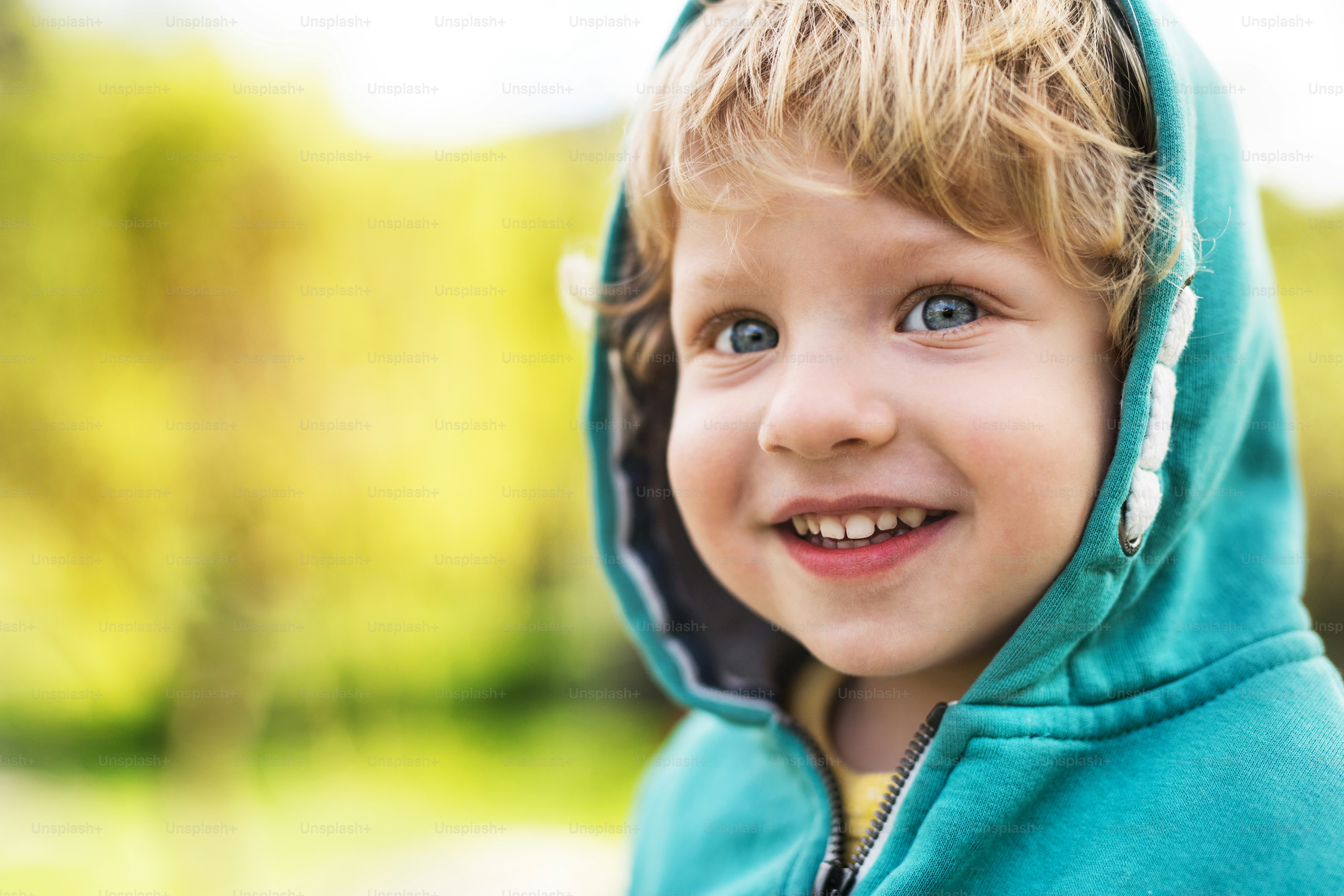 A happy toddler boy outside in spring nature. Close up. Copy space ...