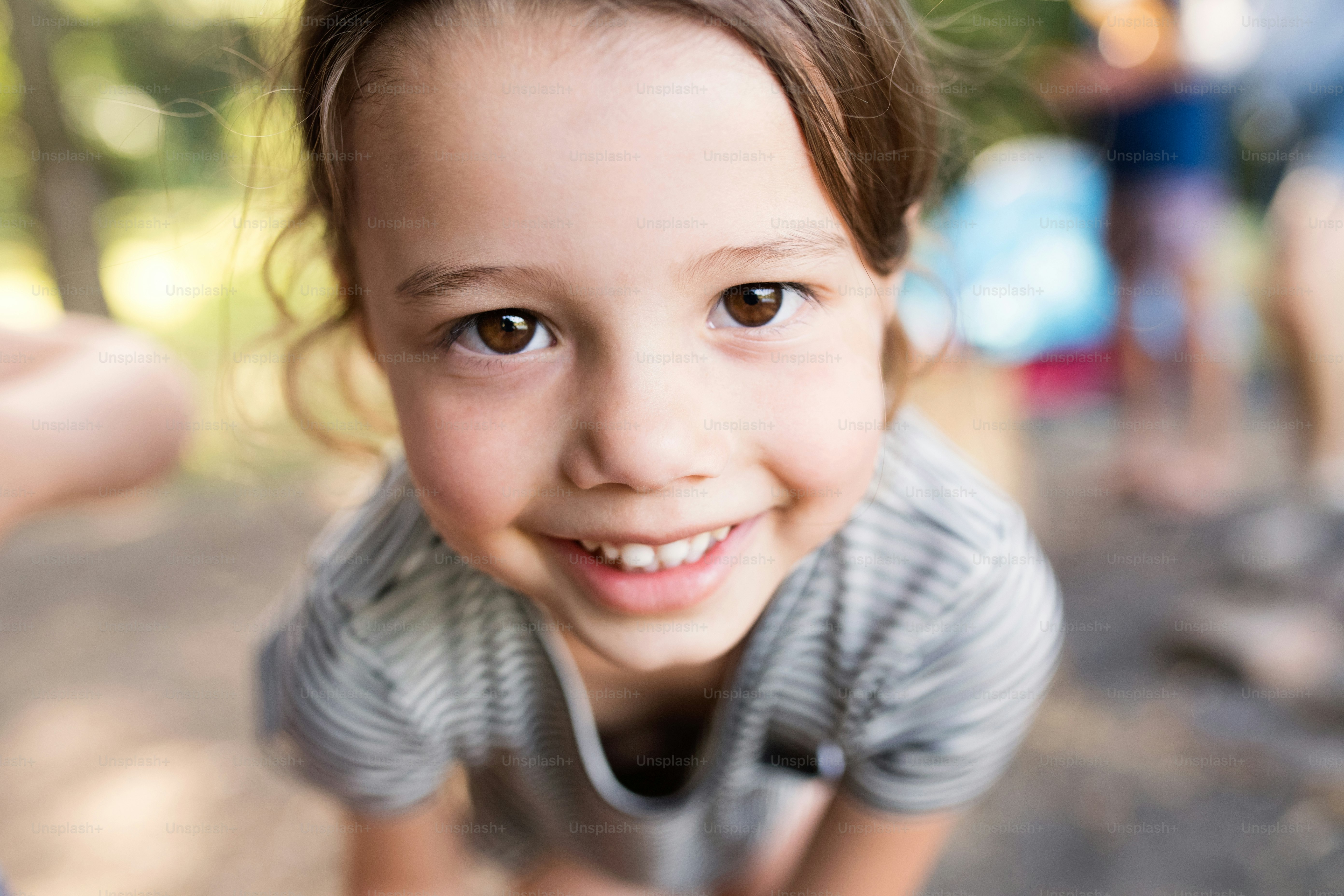 Face of cute little girl outdoors in nature camping with her family ...