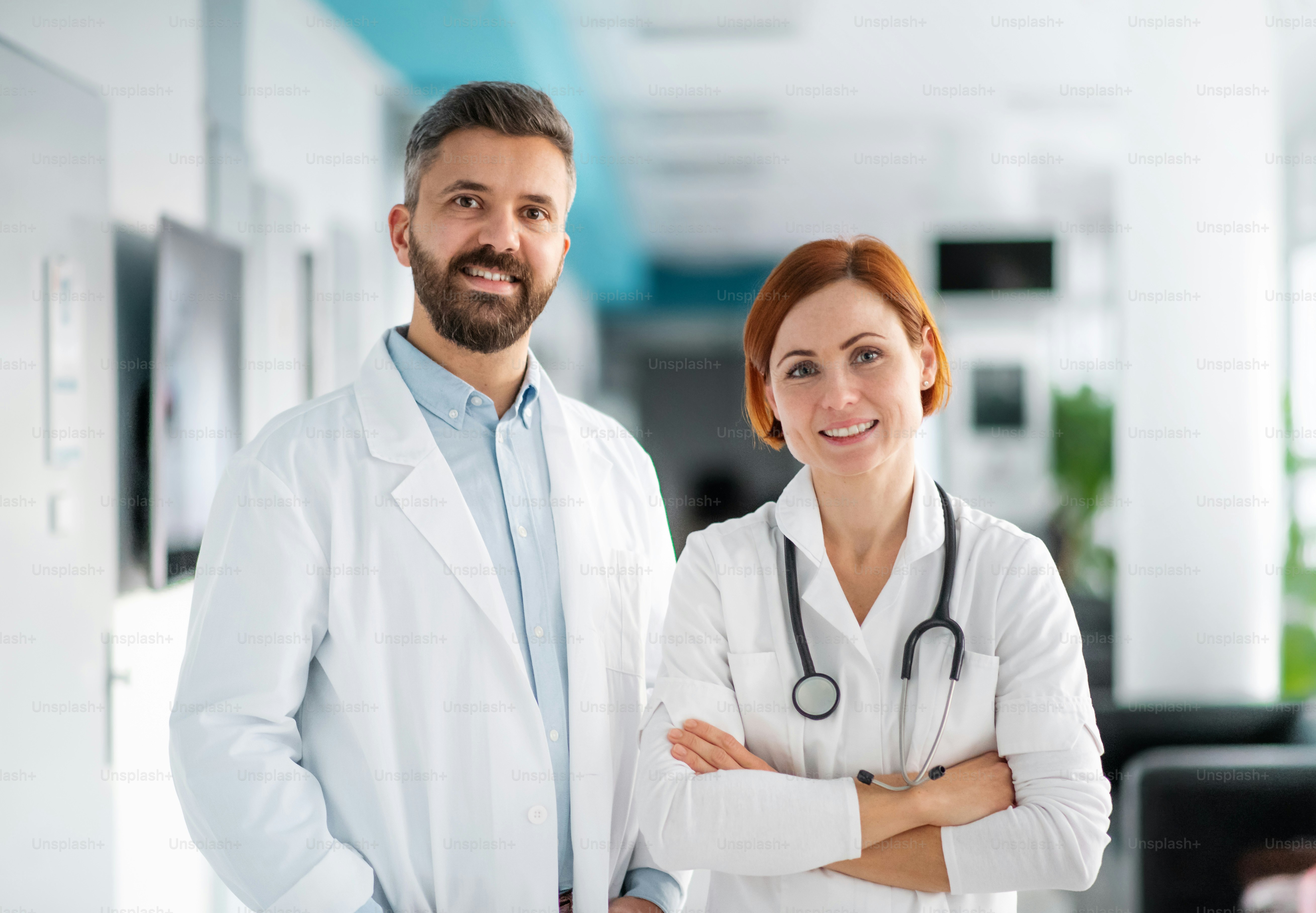 A portrait of man and woman doctor standing in hospital, looking at ...