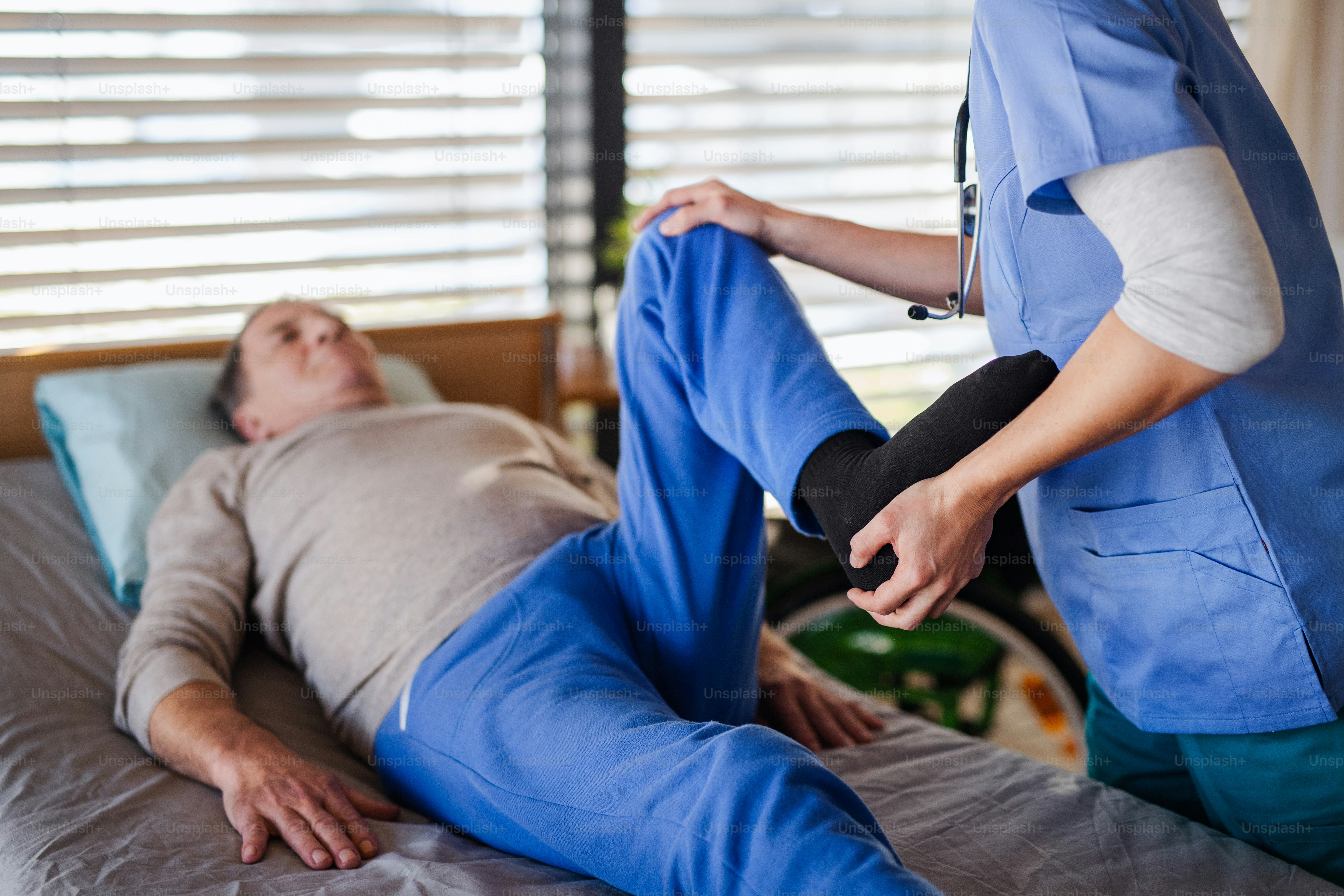A healthcare worker and senior patient in hospital, physiotherapy ...