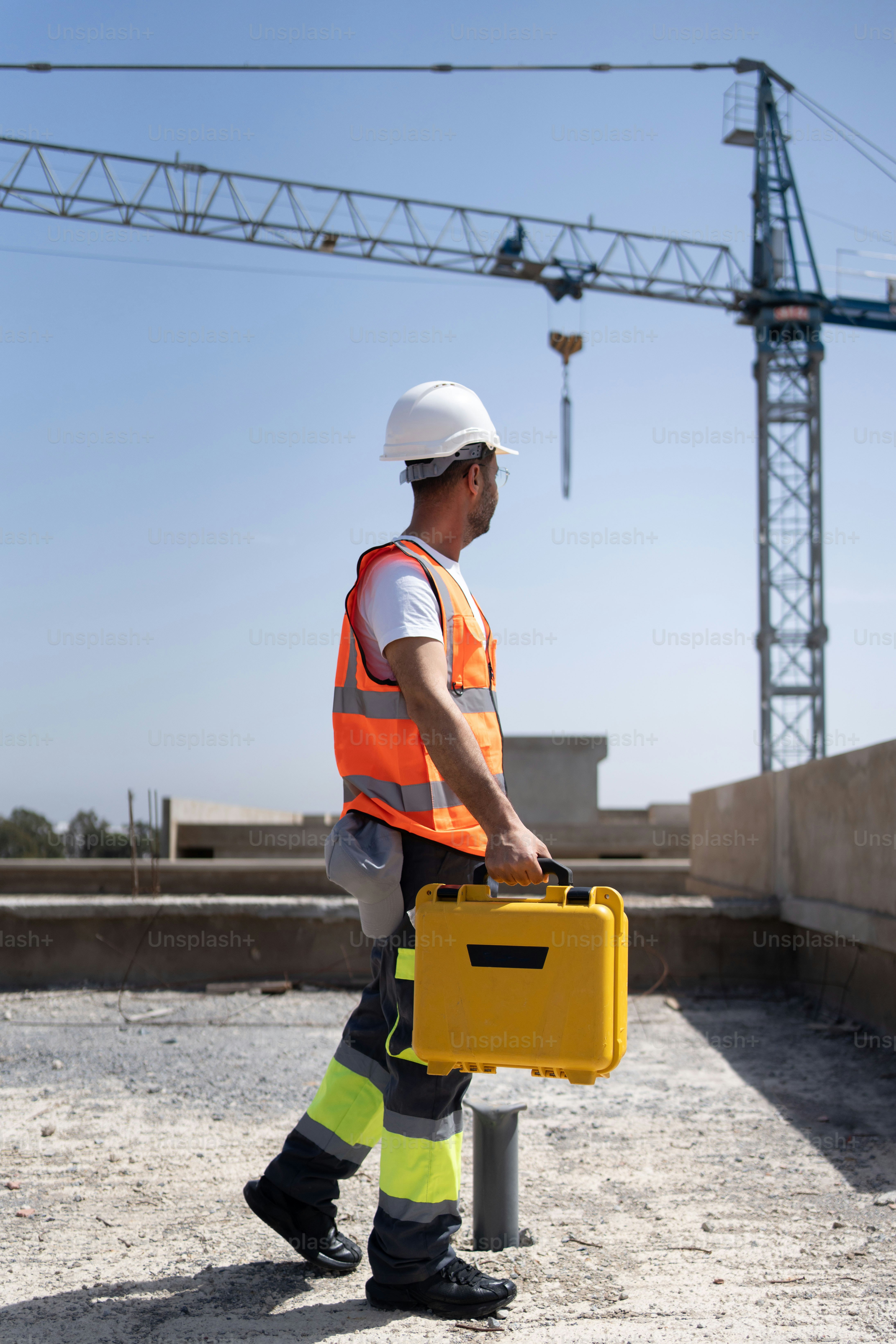 A construction worker carrying a yellow briefcase photo – Architecture ...