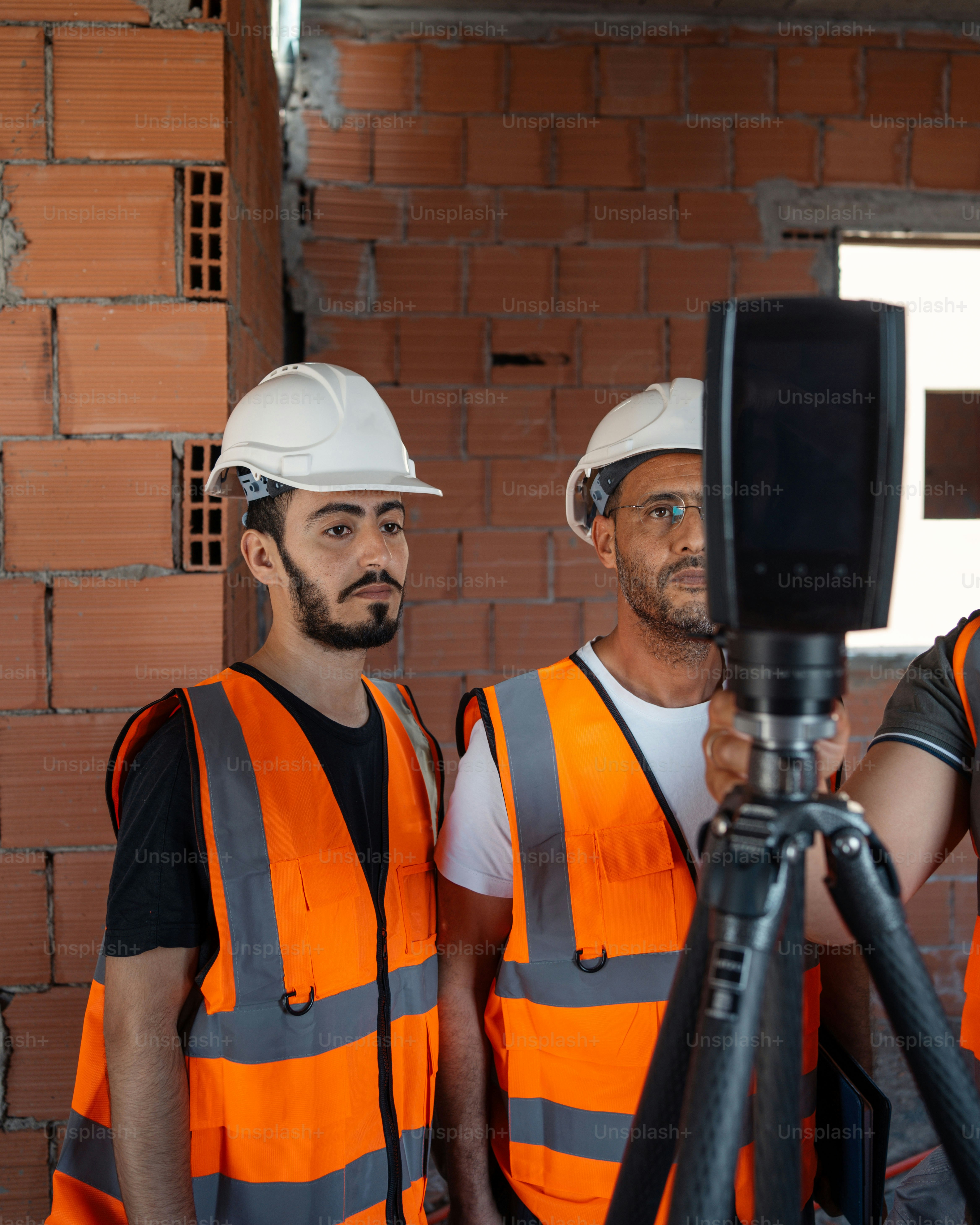 Three construction workers standing in front of a camera photo ...