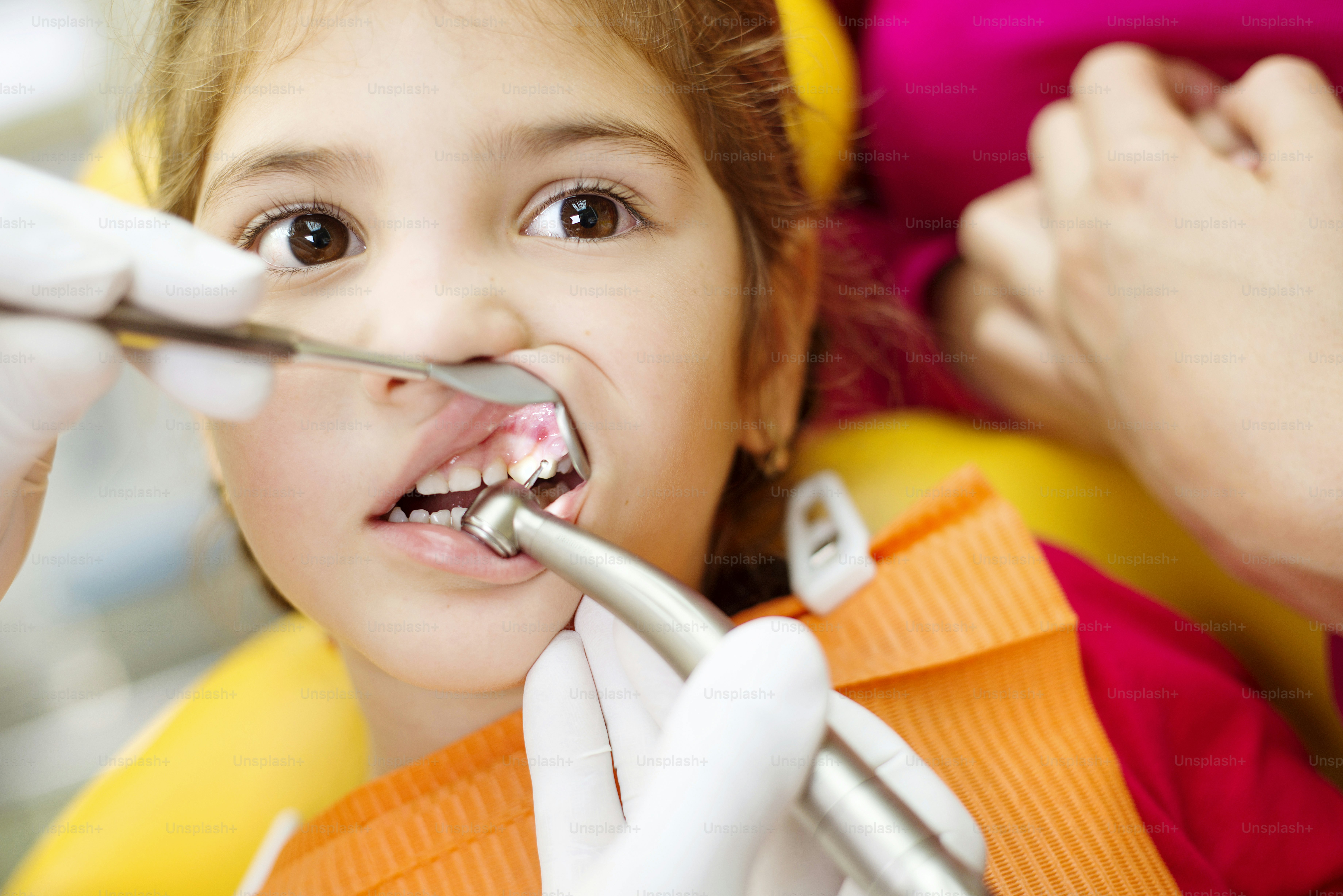 Little girl is having her teeth examined by dentist photo – Dentist ...