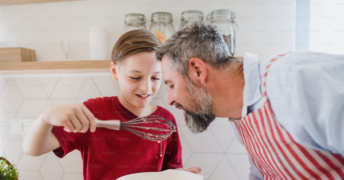 キッチンの屋内で小さな息子を持つ成熟した父親で、パンケーキを作る。の写真 Unsplashの家庭生活の画像
