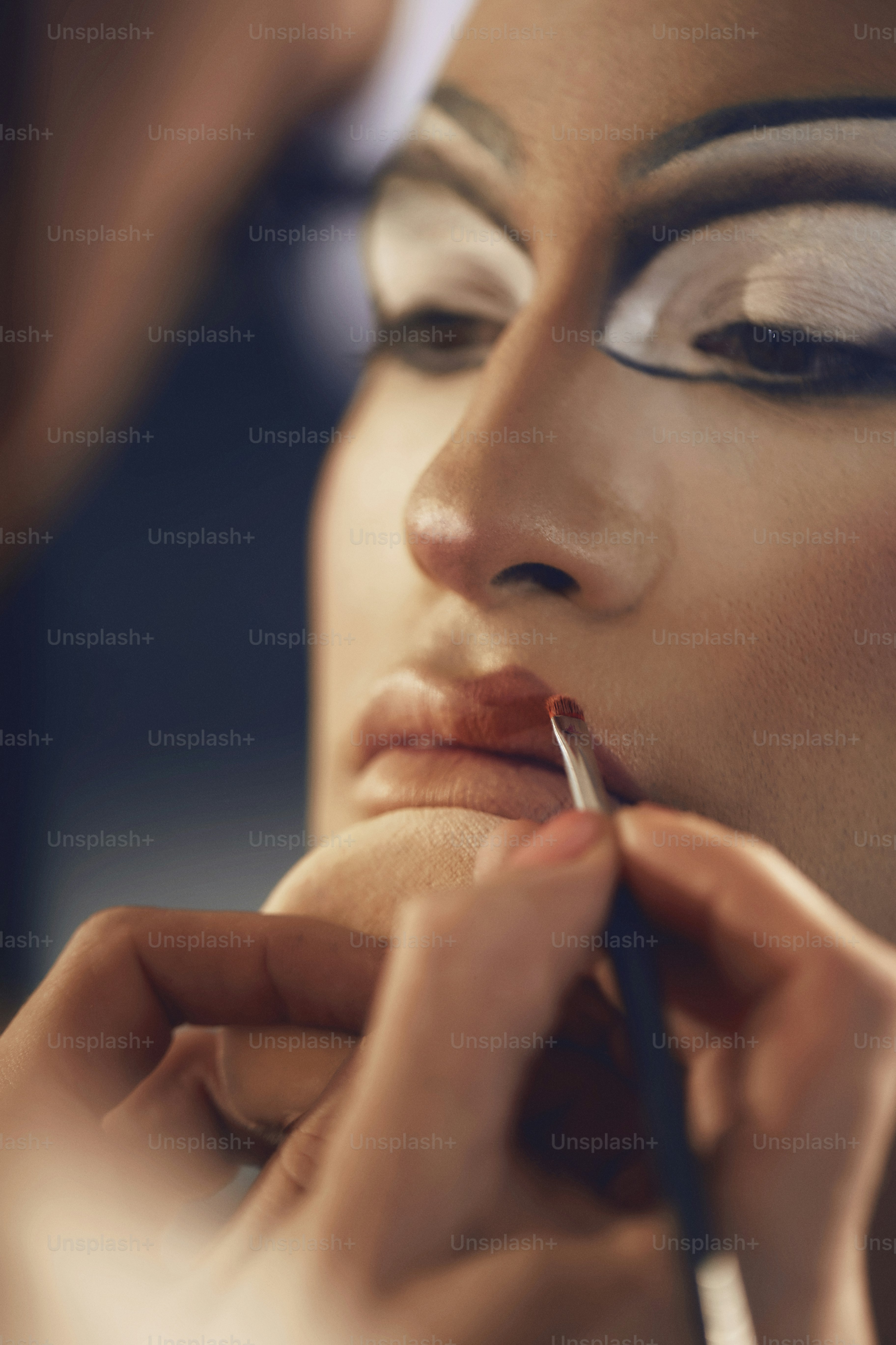 A woman is doing makeup on her face photo – Make up face Image on Unsplash